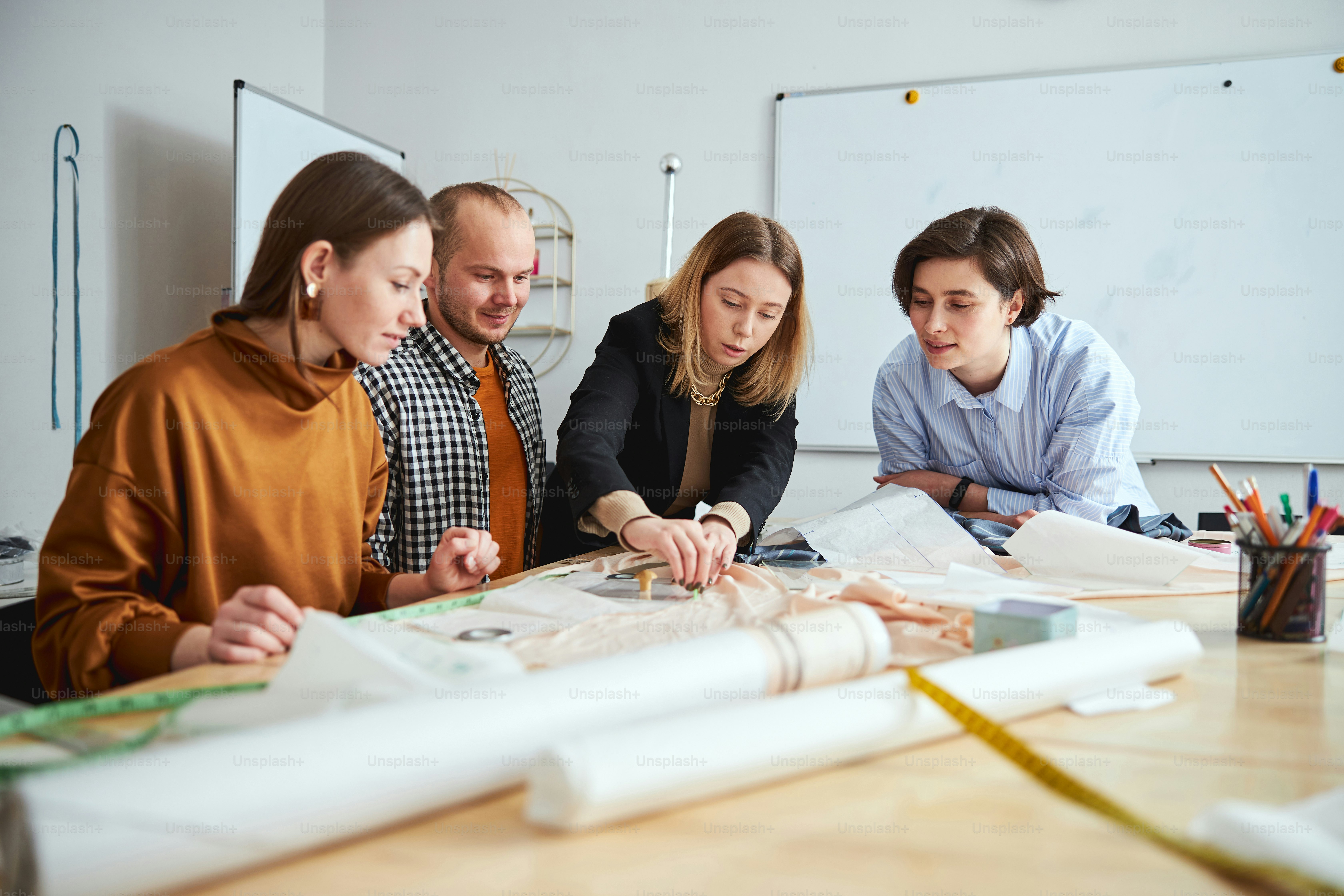 Ruhige Modedesignerin, die ein Lineal auf dem Kleidungsmuster verwendet ...