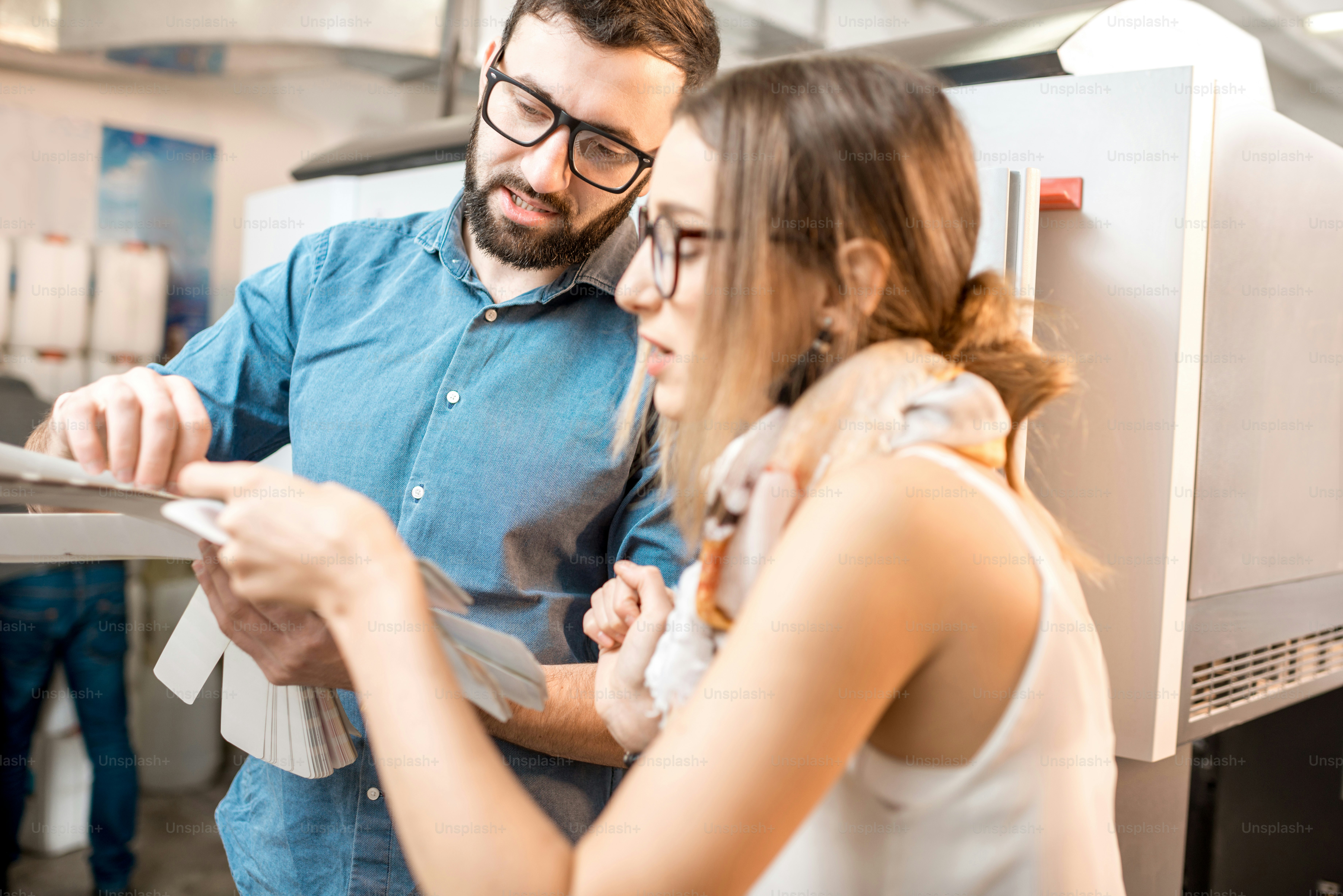 Young woman designer and print operator working together at the print ...