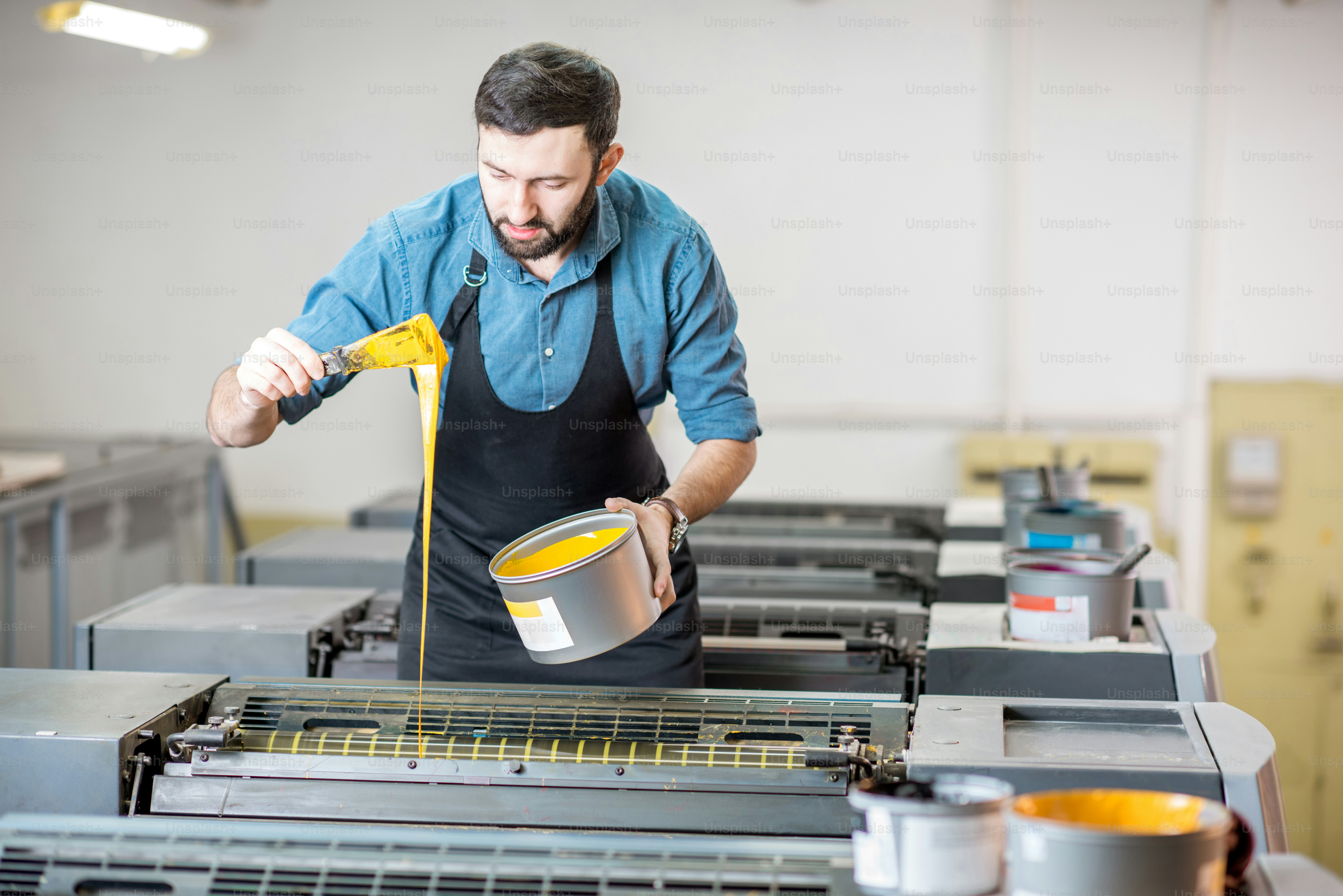 Worker following a printing process on the offset machine at the ...