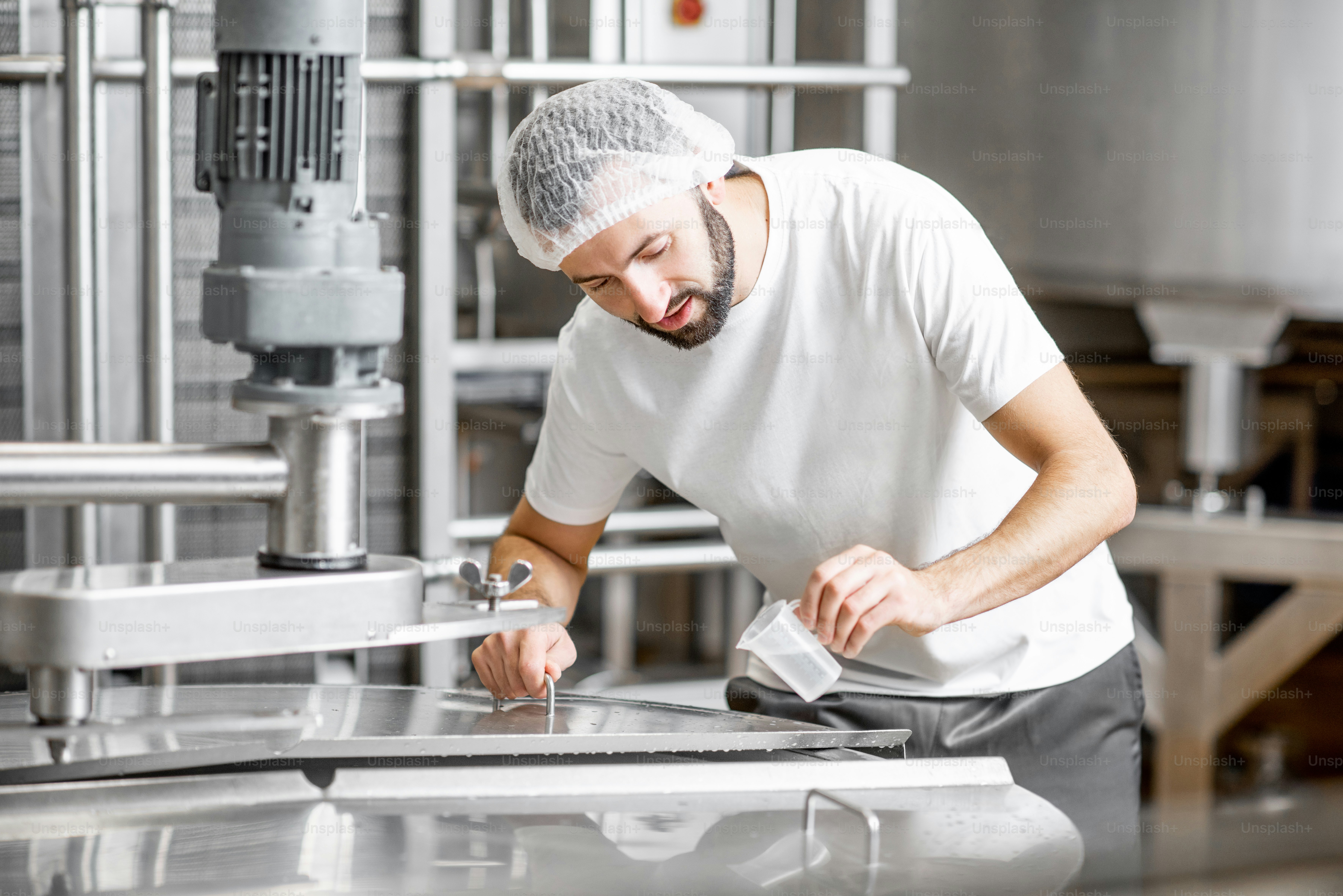 Worker adding supplements during the milk fermentation process in the ...