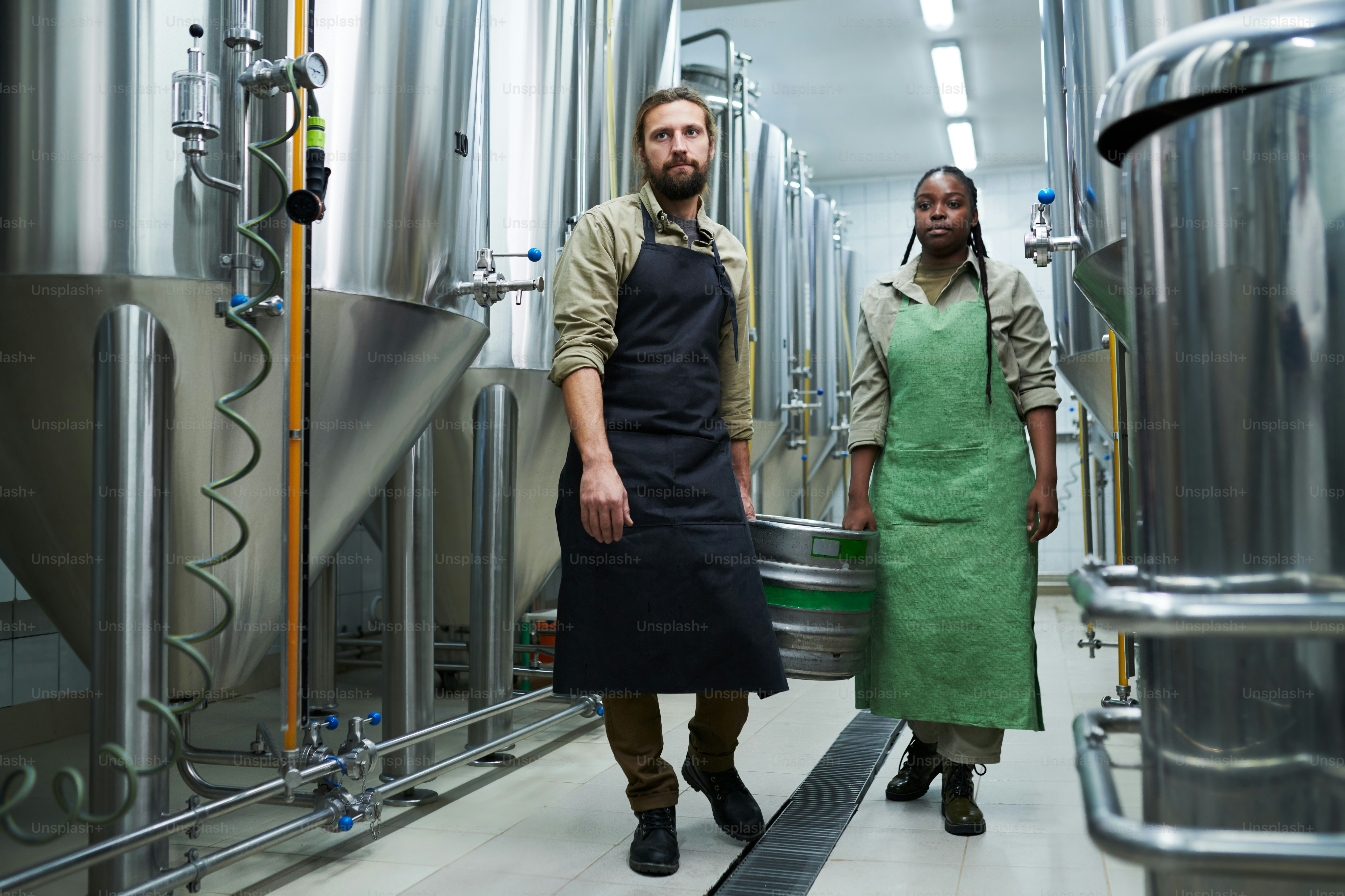 Brewery workers carrying keg with fresh beer to warehouse photo ...