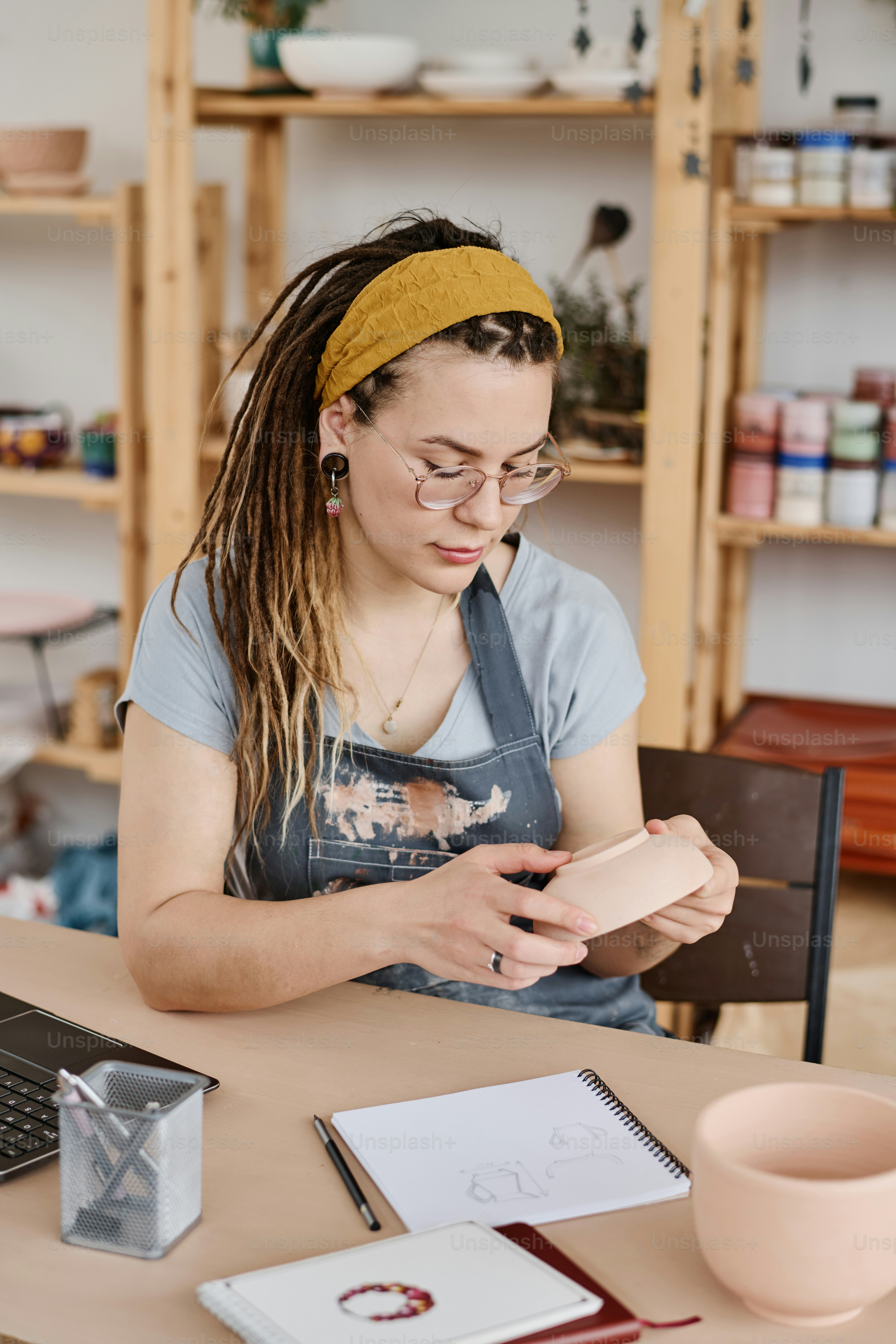 Joven alfarera seria mirando el fondo de un cuenco de arcilla en sus ...