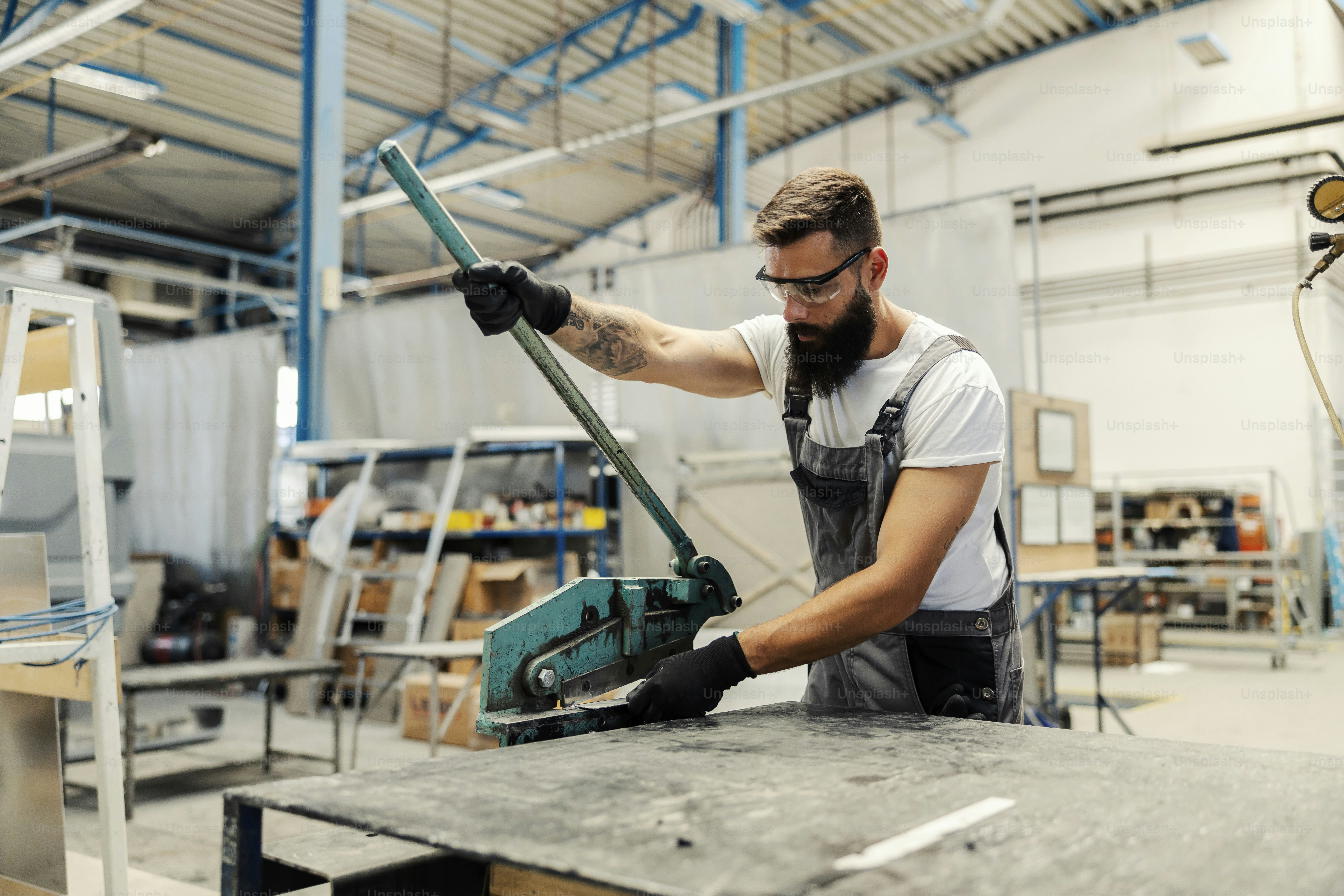A worker using manual metal cutter for cutting metal parts. photo ...