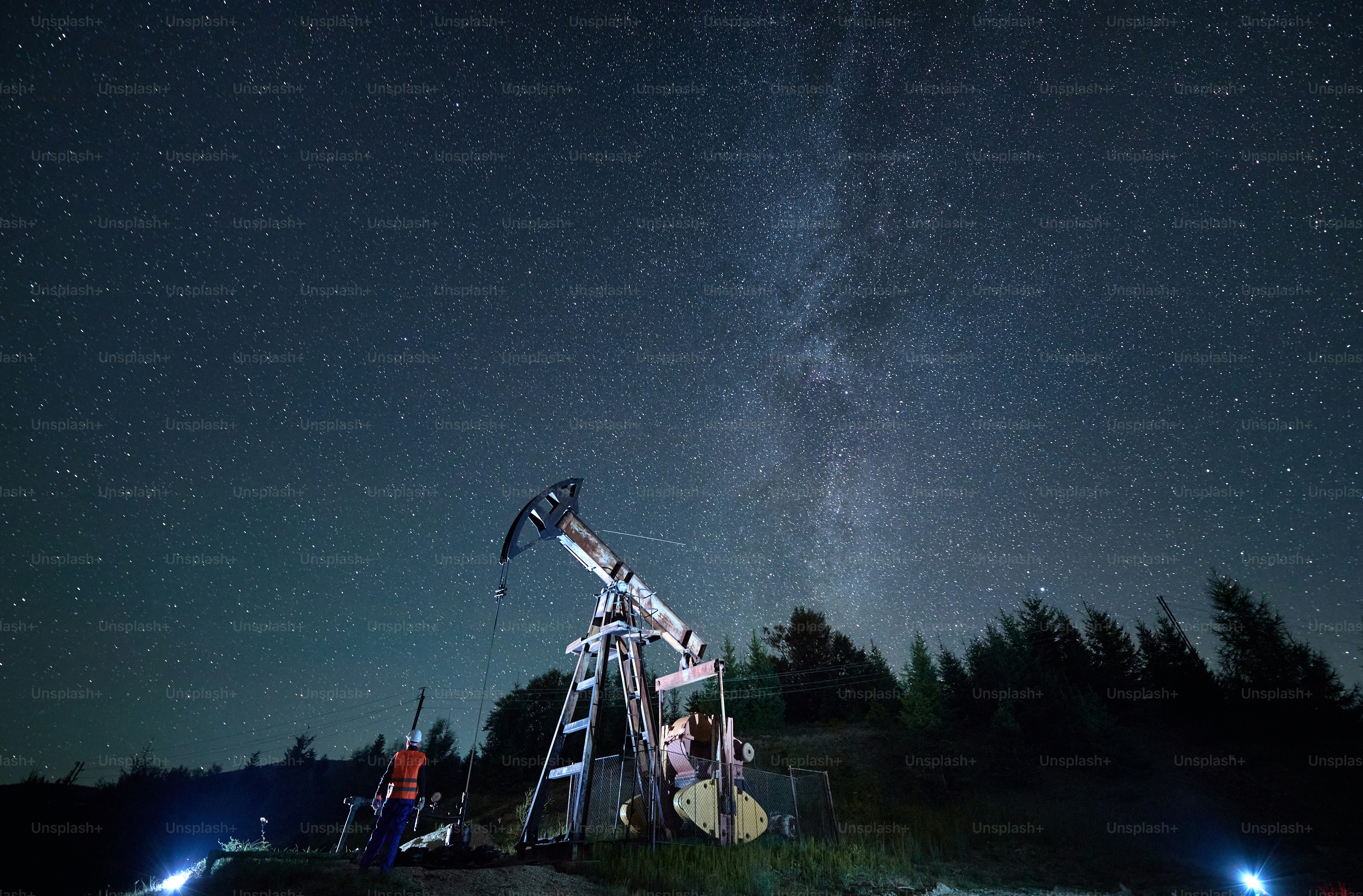 Back view of professional technician in uniform and helmet looking at ...