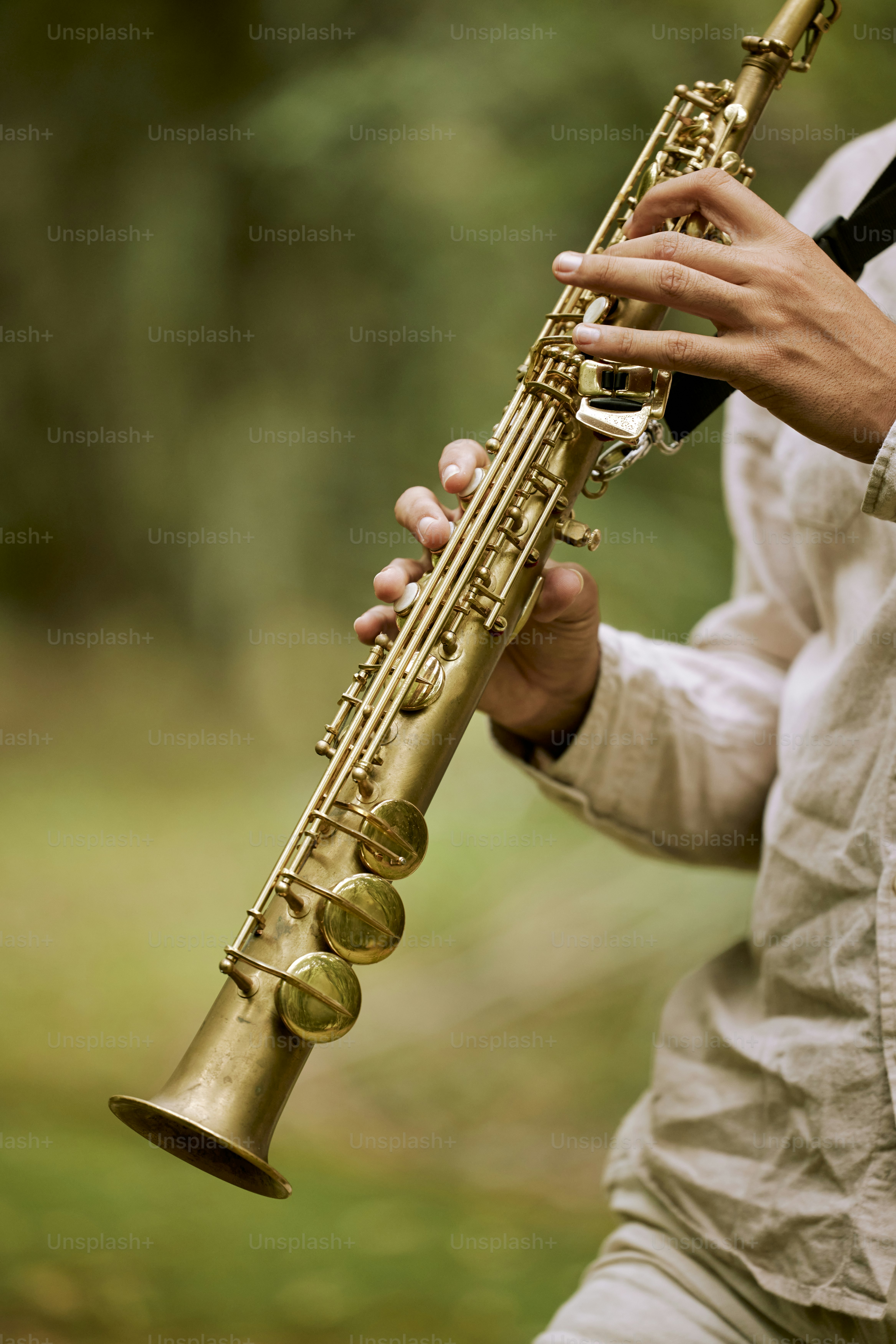 A man playing a saxophone in a forest photo – Musician Image on Unsplash