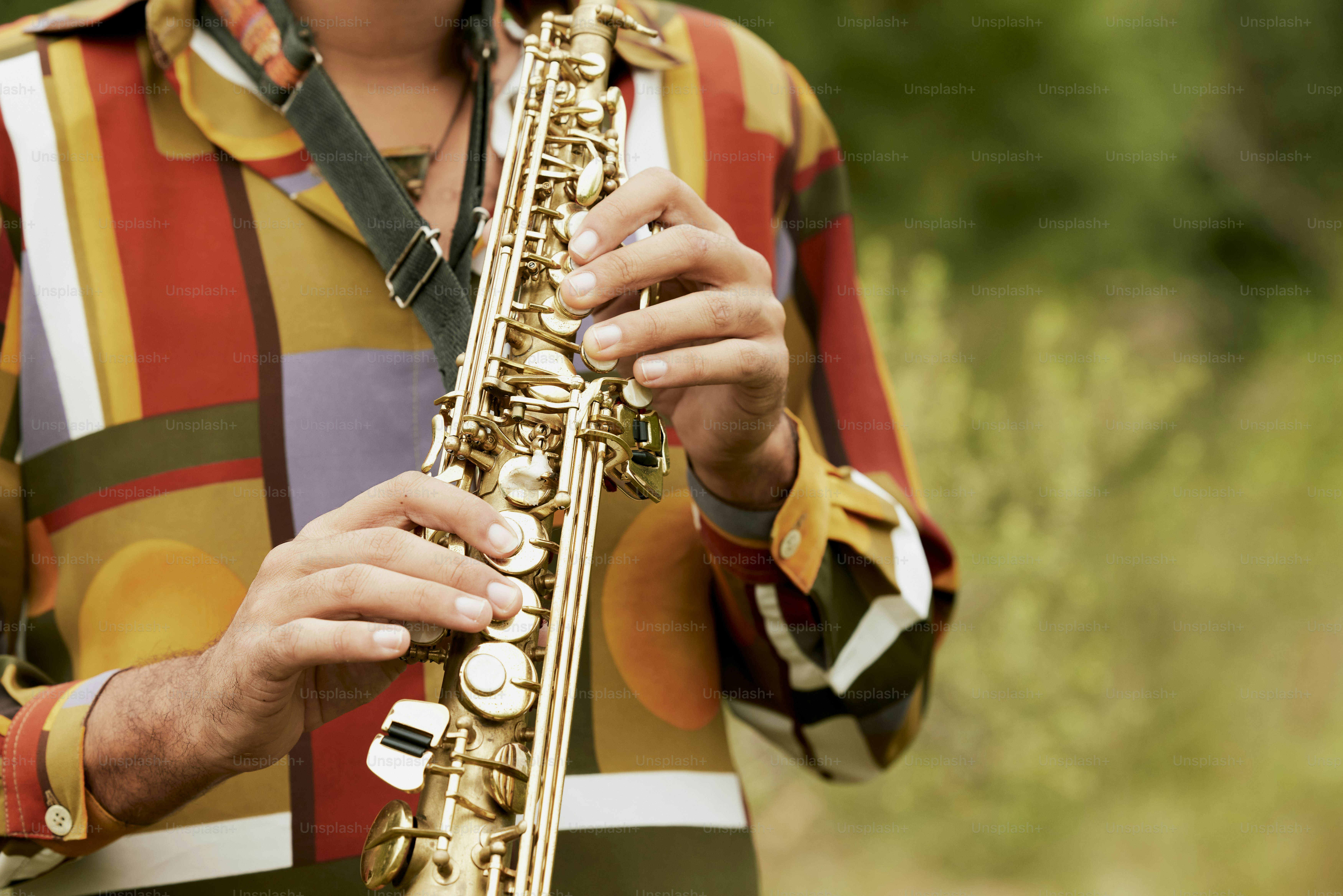 Un homme tenant un saxophone dans ses mains photo – Saxophone Photo sur ...