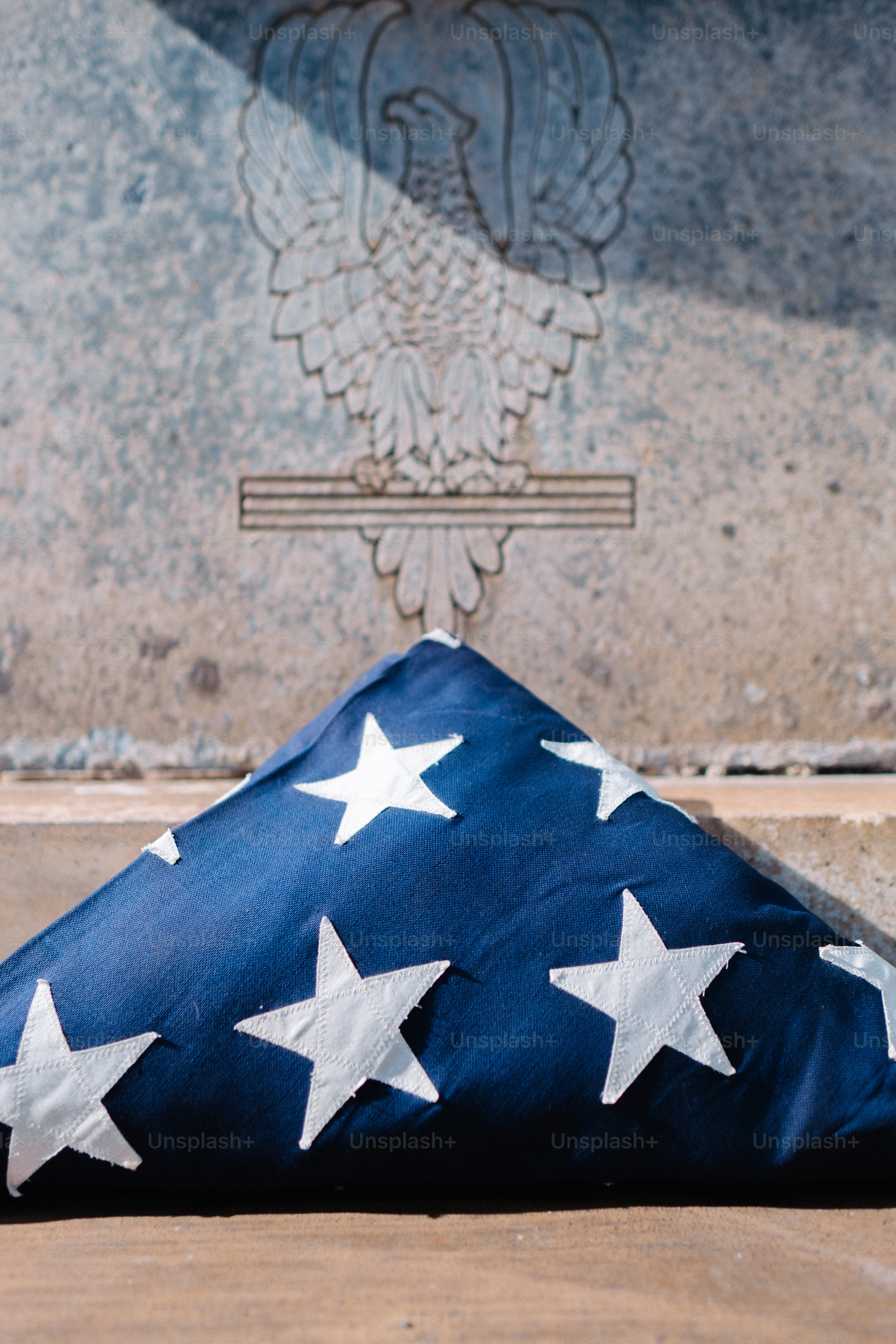 A flag laying on the ground in front of a monument photo – American ...