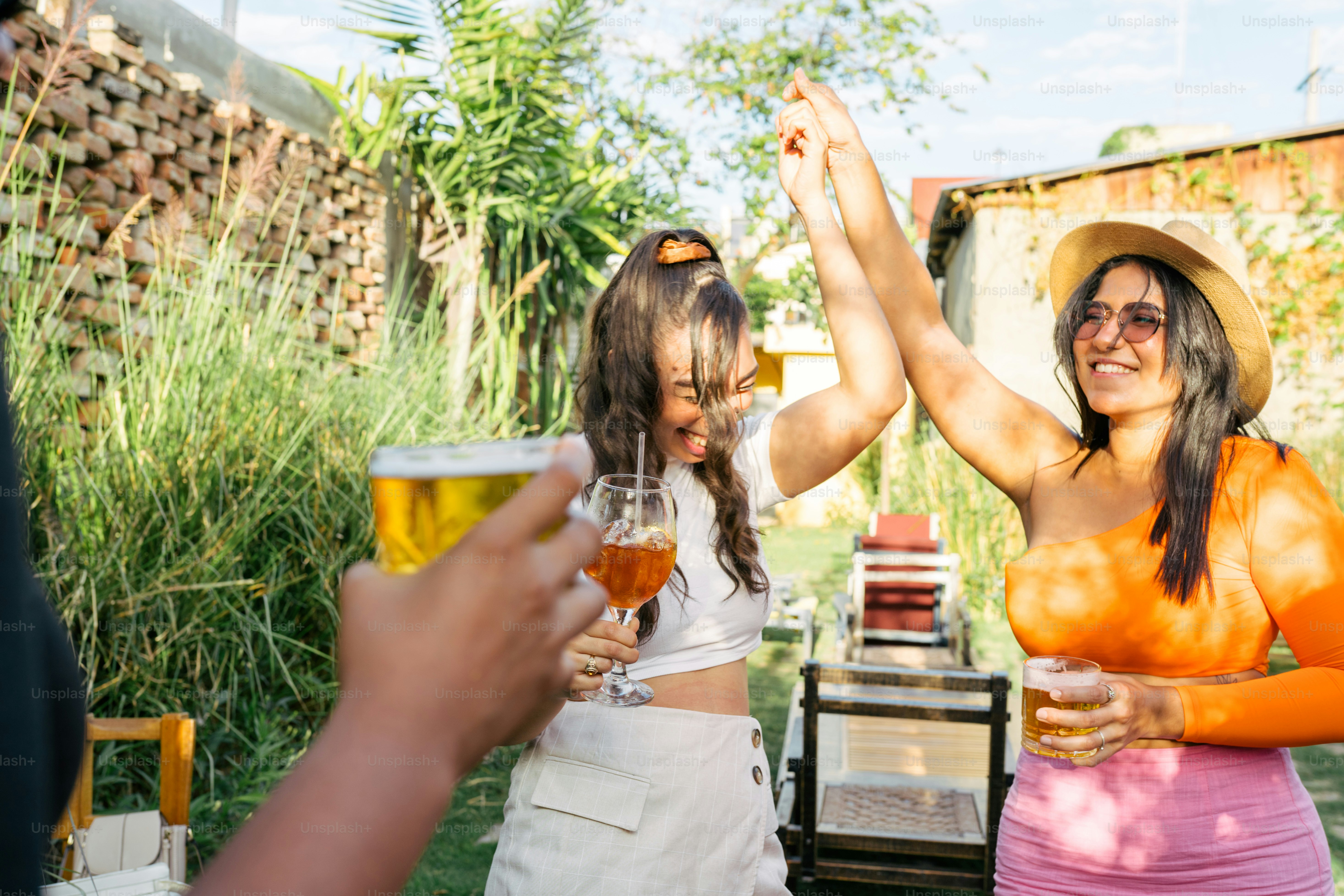 A couple of women standing next to each other photo – Outdoor party ...