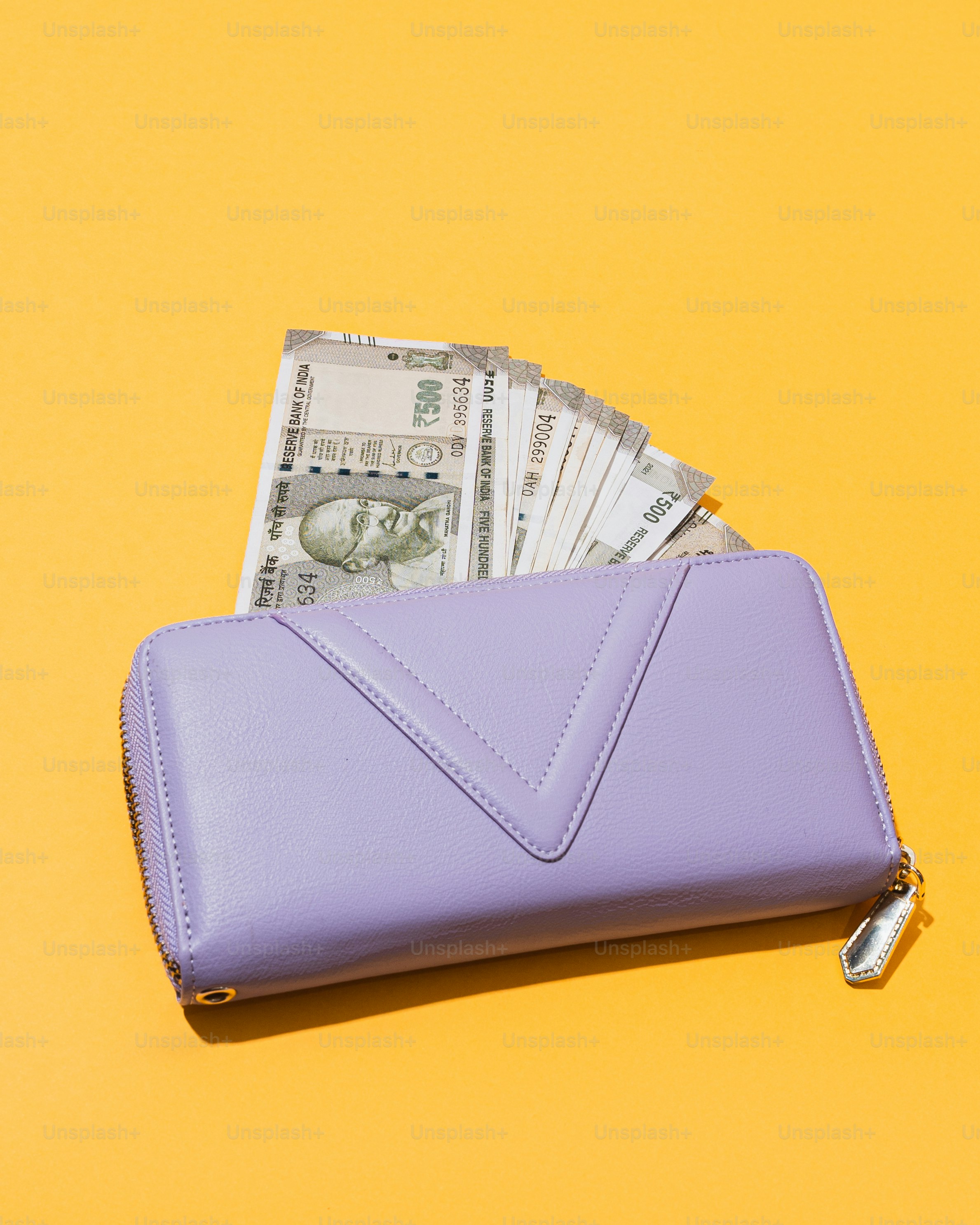 A purple wallet with money sticking out of it photo – Bank notes Image ...