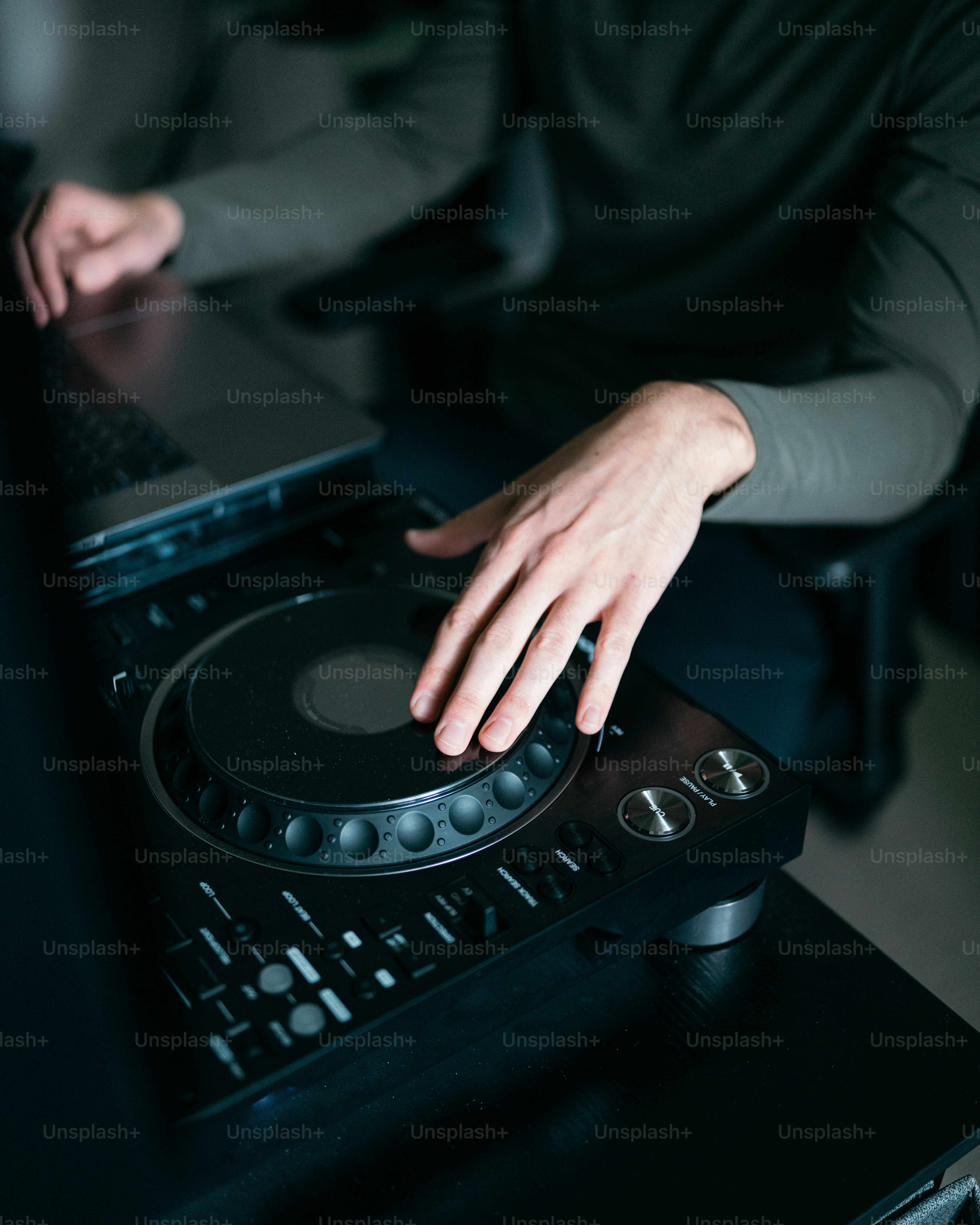 A person using a dj's turntable in front of a laptop photo – Music ...
