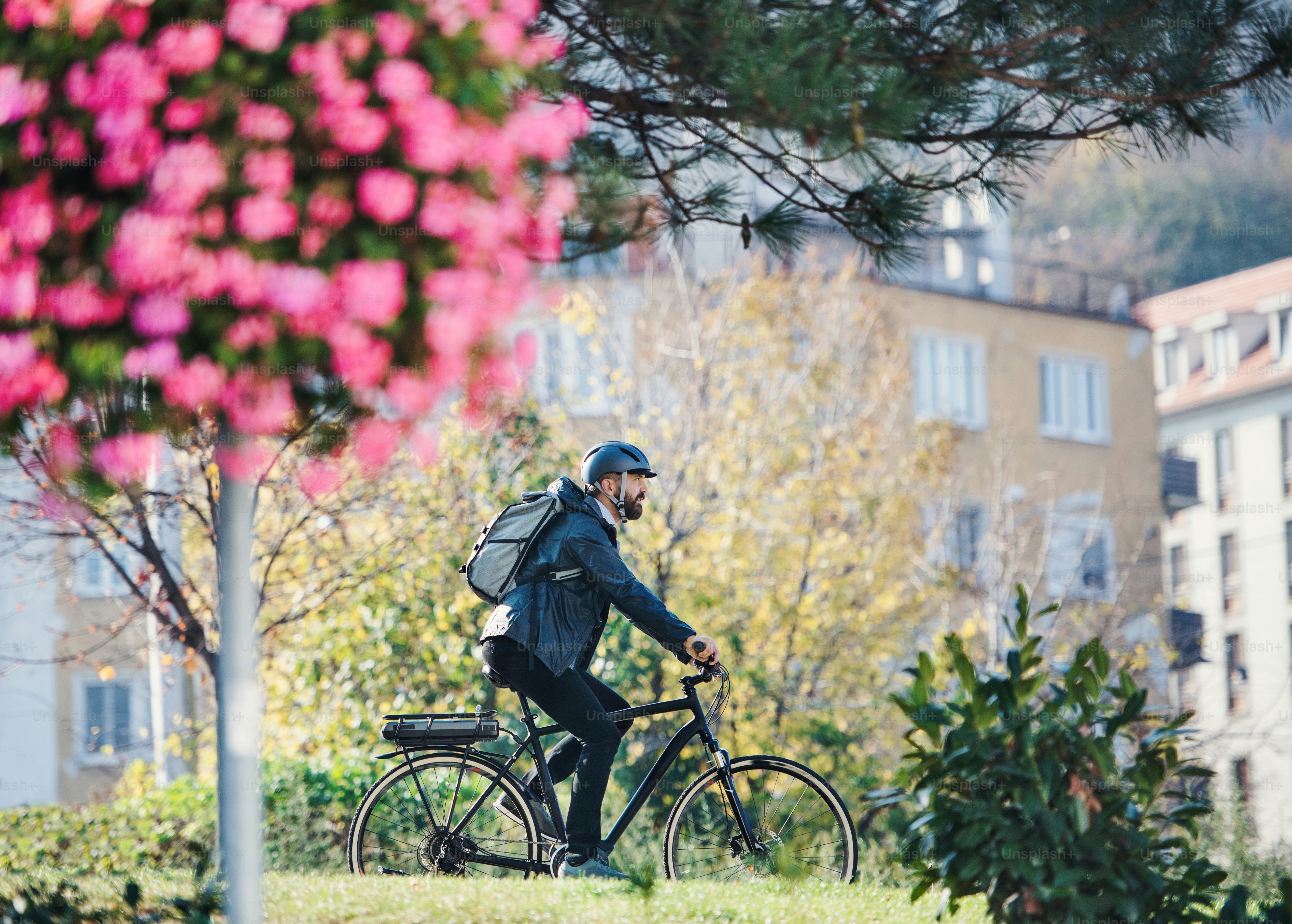 A side view of hipster businessman commuter with bicycle traveling to ...