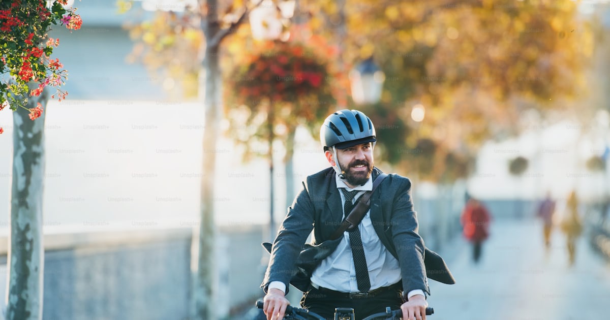 Hipster-Geschäftsmann, Pendler mit Elektrofahrrad, der bei ... Hipster-Geschäftsmann, Pendler mit Elektrofahrrad, der bei ...