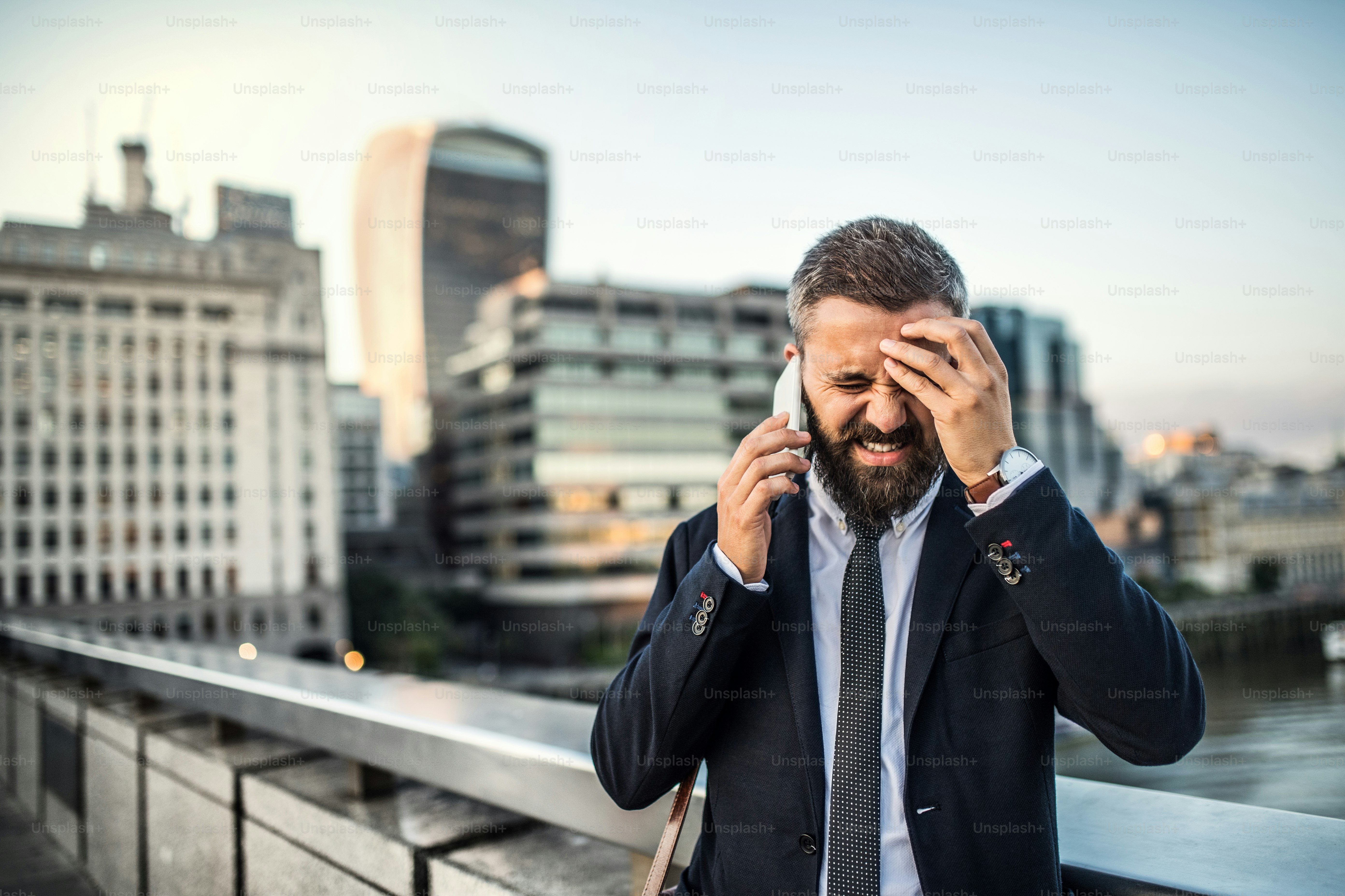 Angry and frustrated hipster businessman with smartphone standing on ...
