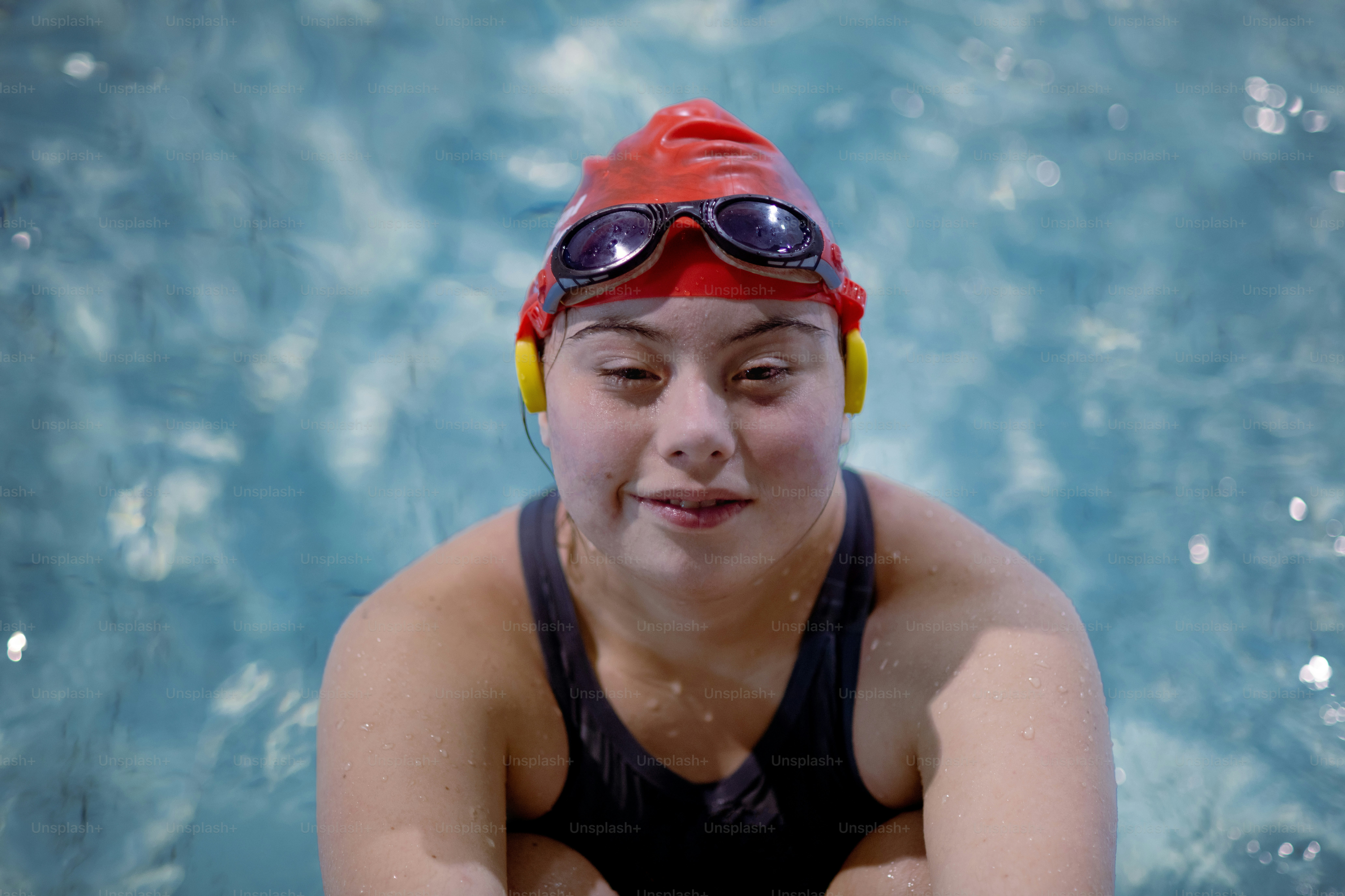 Une jeune femme atteinte du syndrome de Down nageant dans une piscine ...