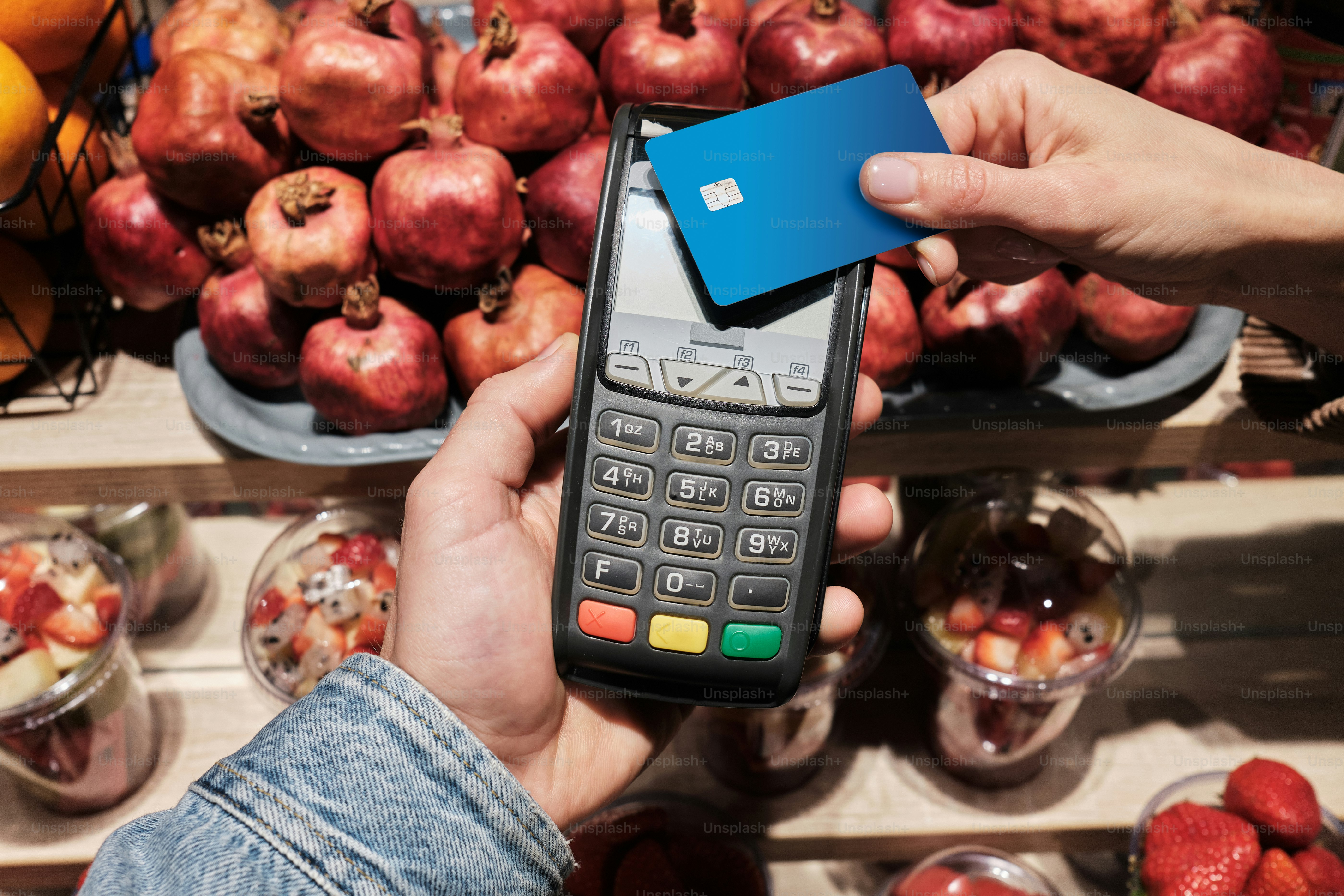 A person holding a credit card in front of a cash register photo ...