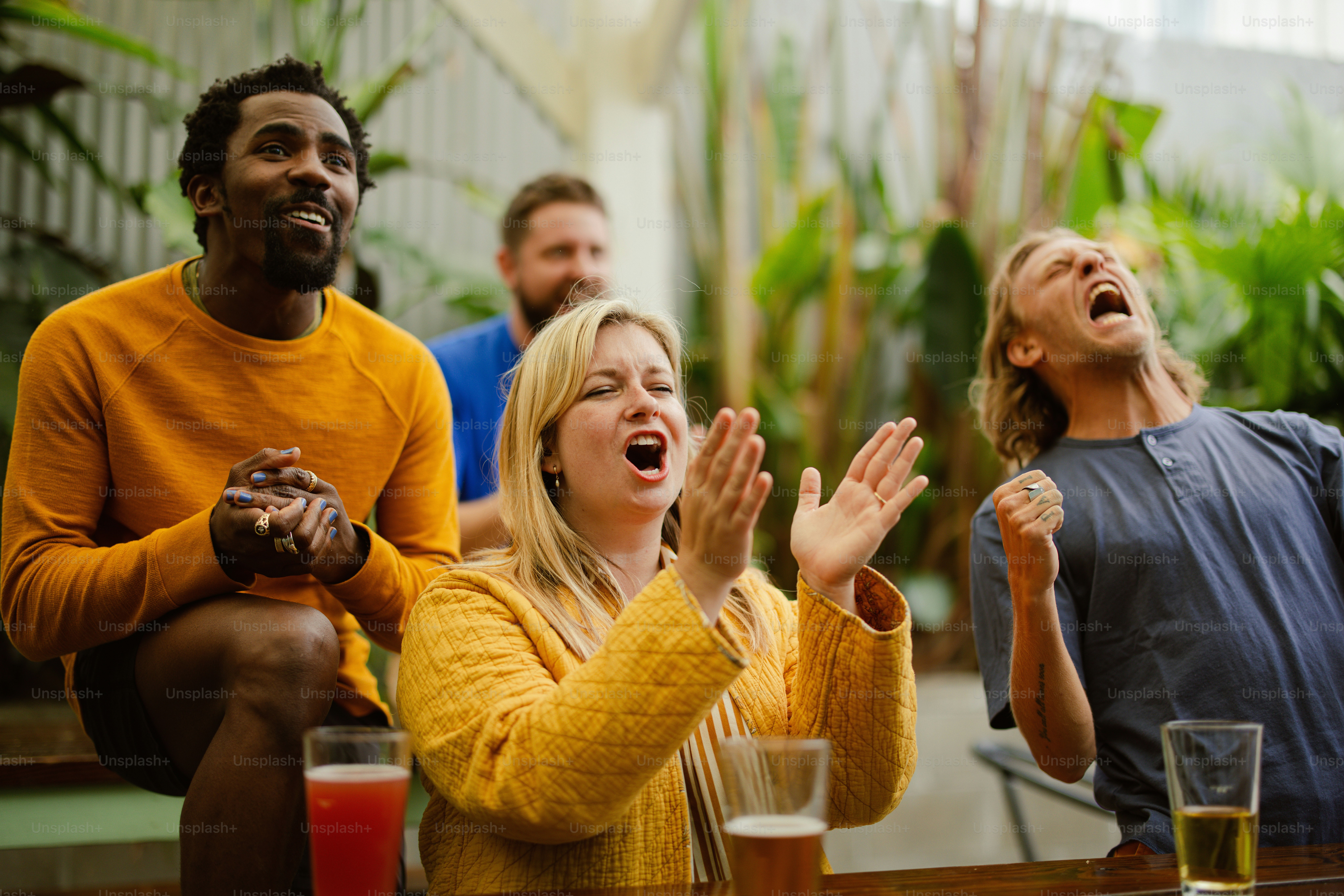 A group of people sitting at a table clapping photo – Cheering Image on ...