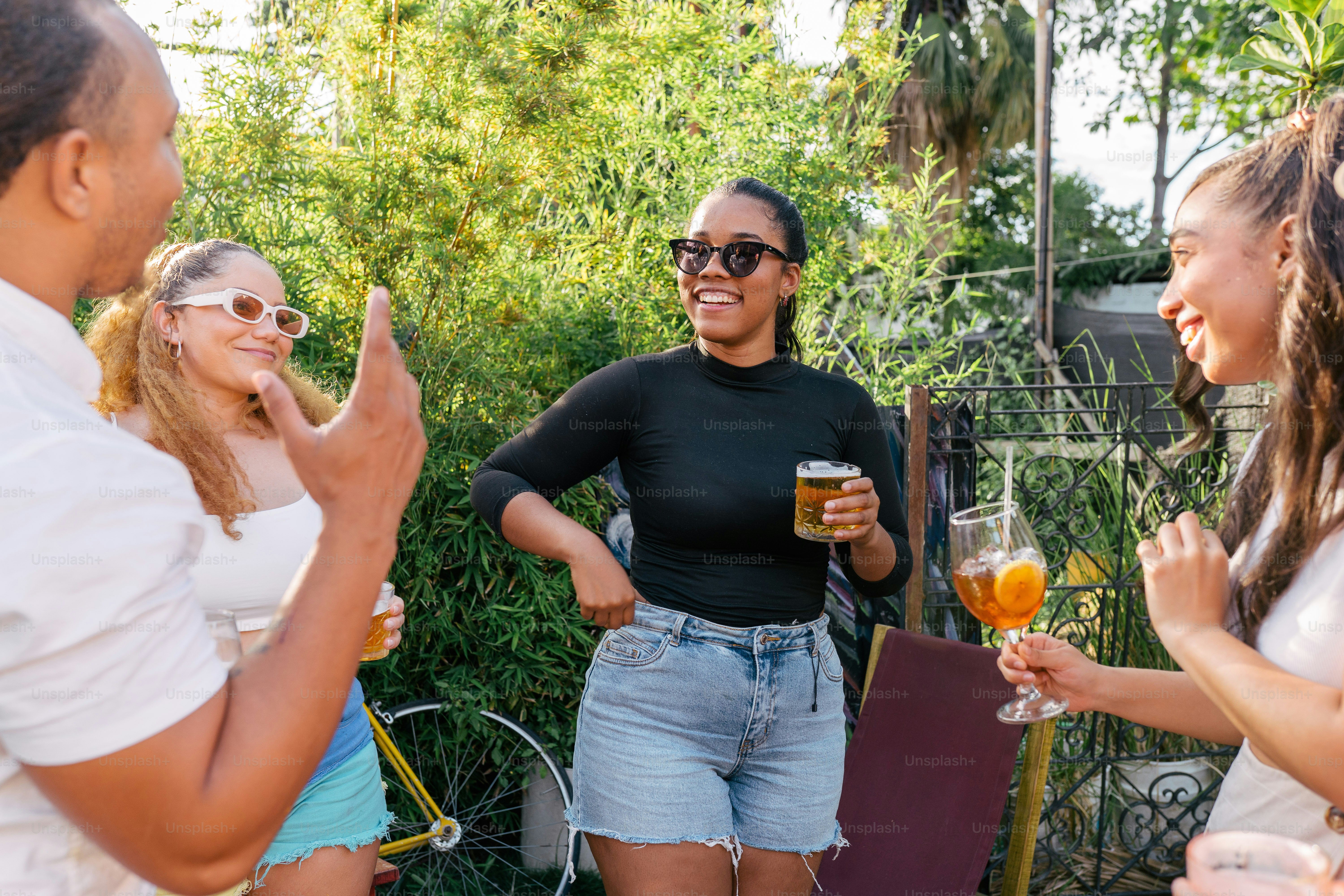 A group of people standing around a wooden table photo – Backyard party ...
