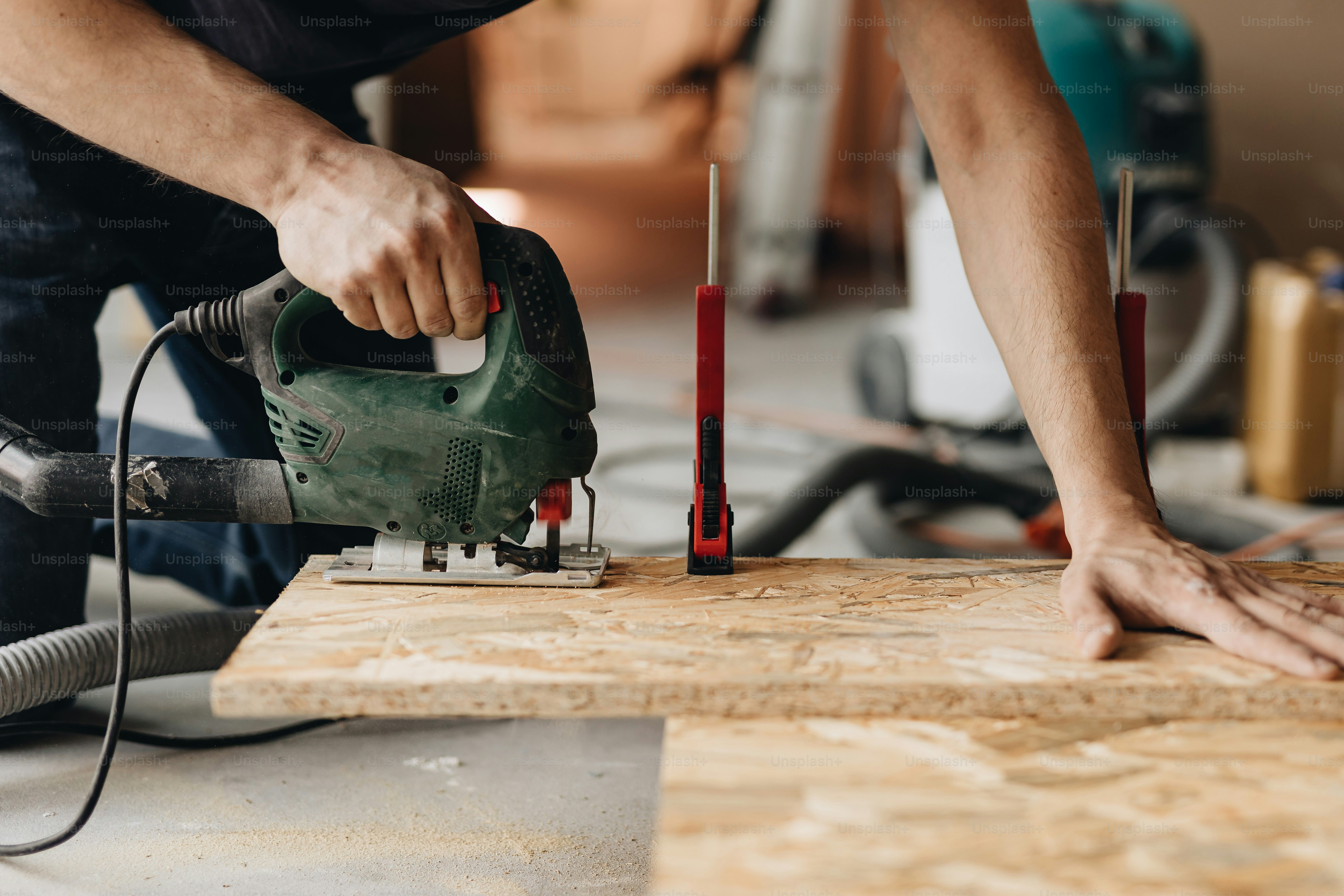 A man sanding a piece of wood with a sander photo – Construction Image ...