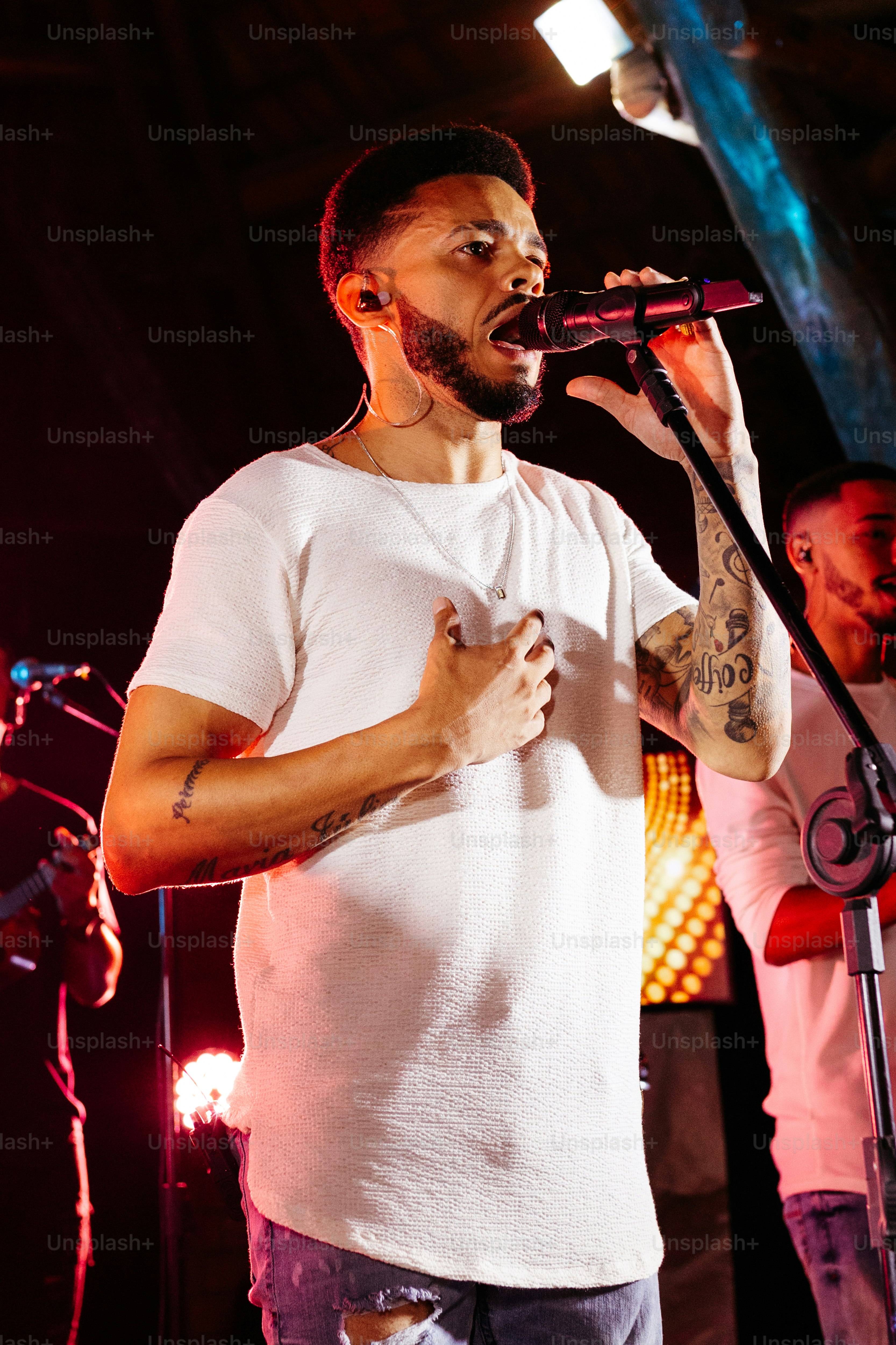 A man singing into a microphone on stage photo – Singer Image on Unsplash