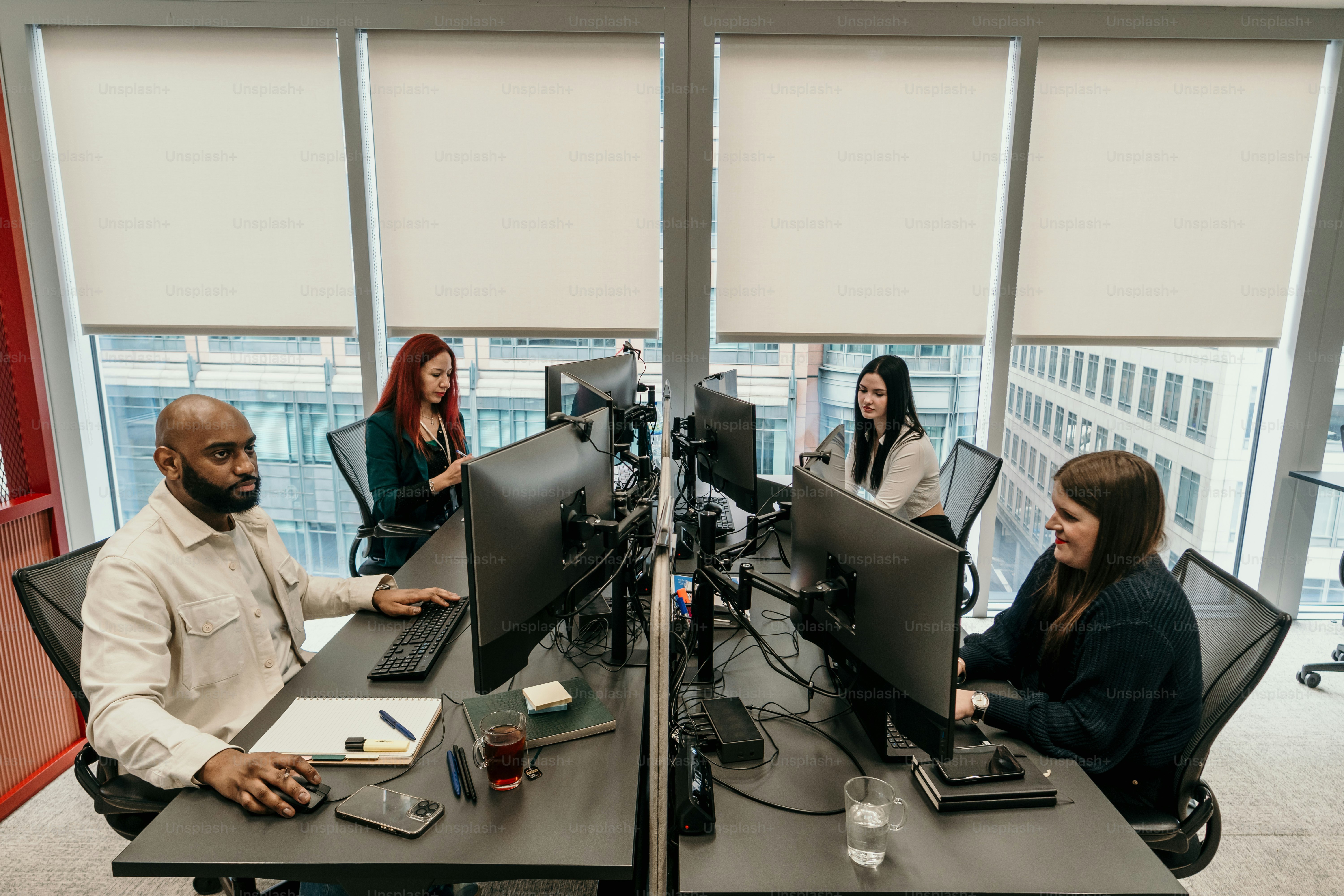 A person sitting at a desk in an office photo – Desk office Image on ...