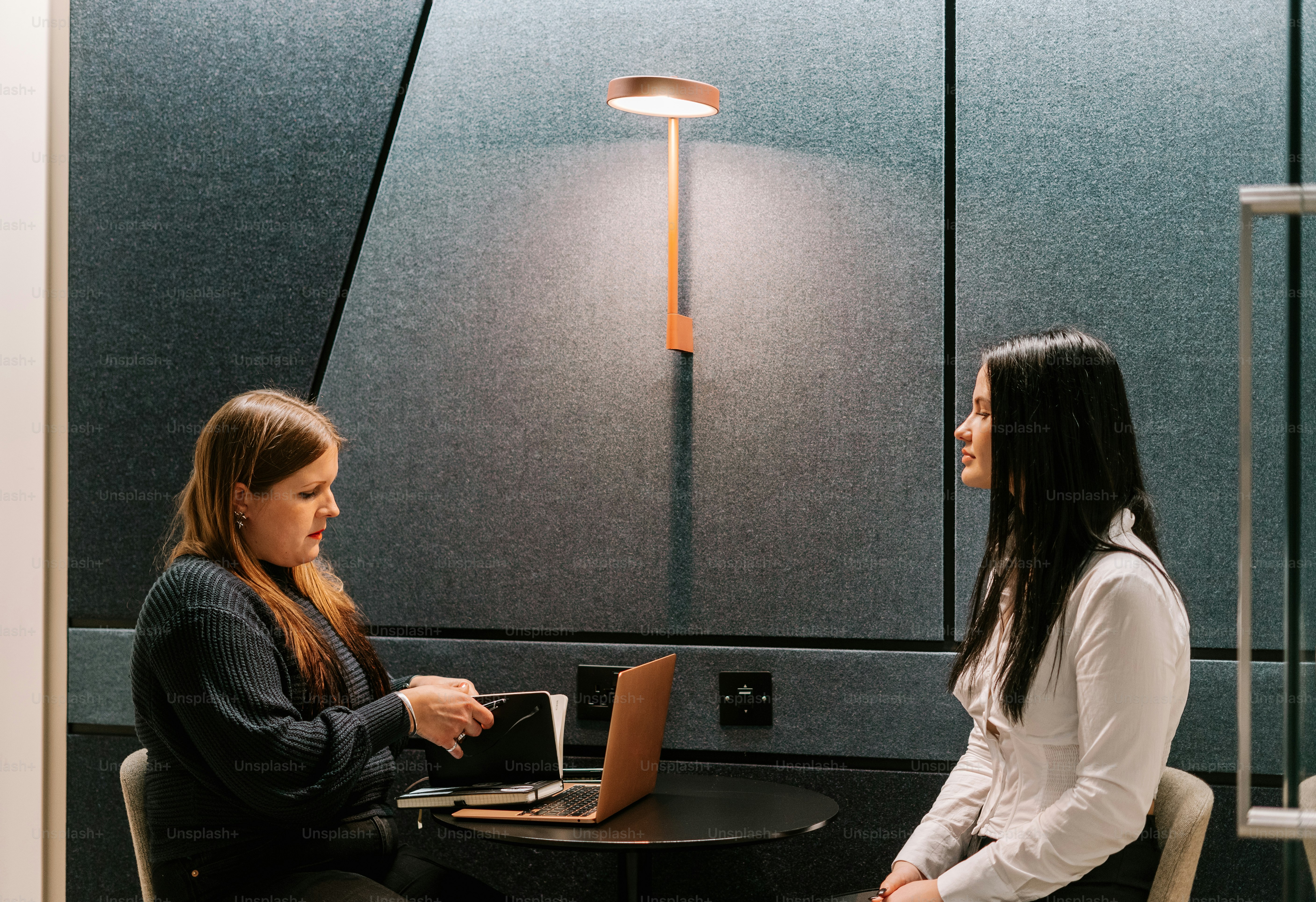 A person sitting at a desk in an office photo – Desk office Image on ...