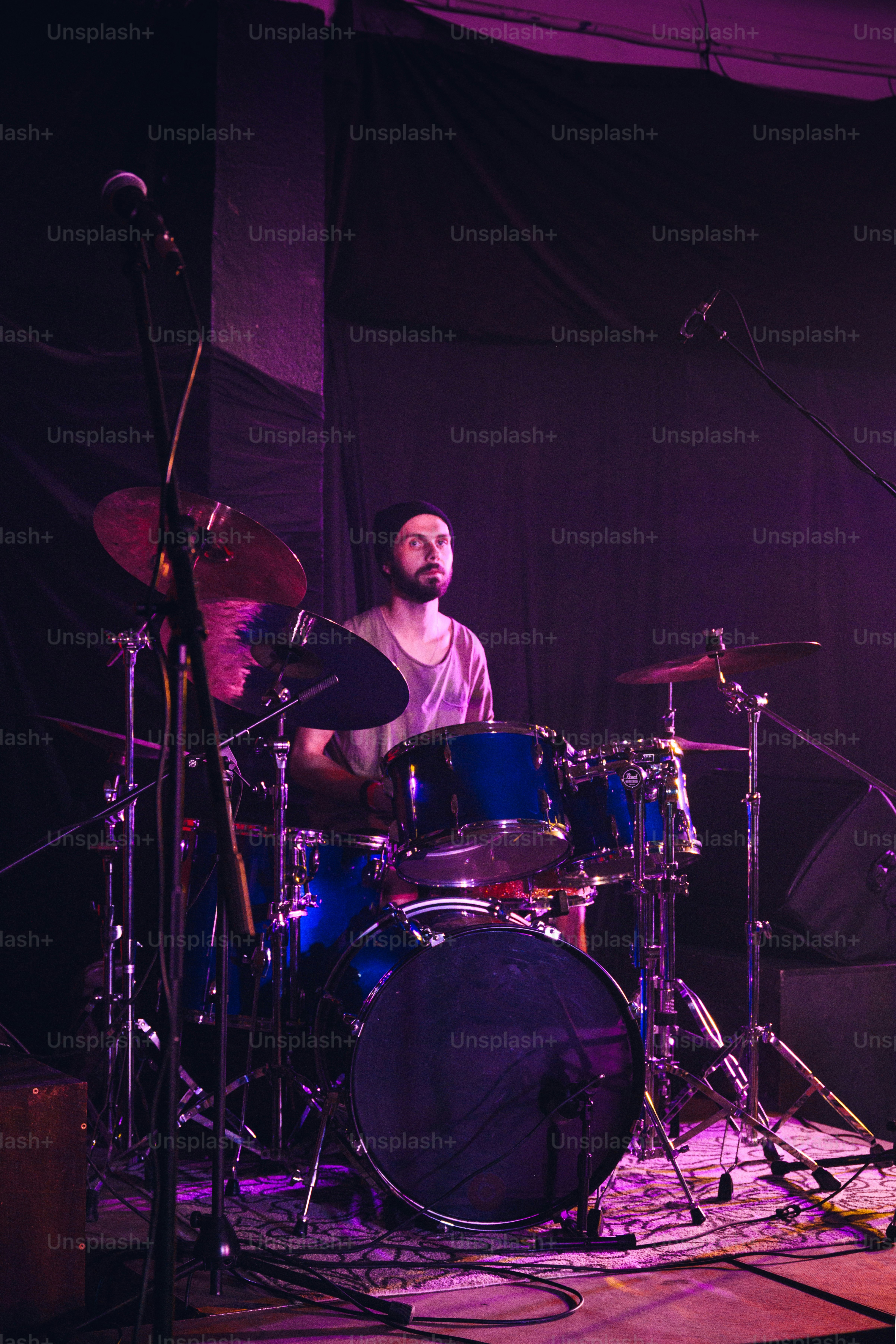 A man with a beard playing drums on stage photo – Rehearsal Image on ...