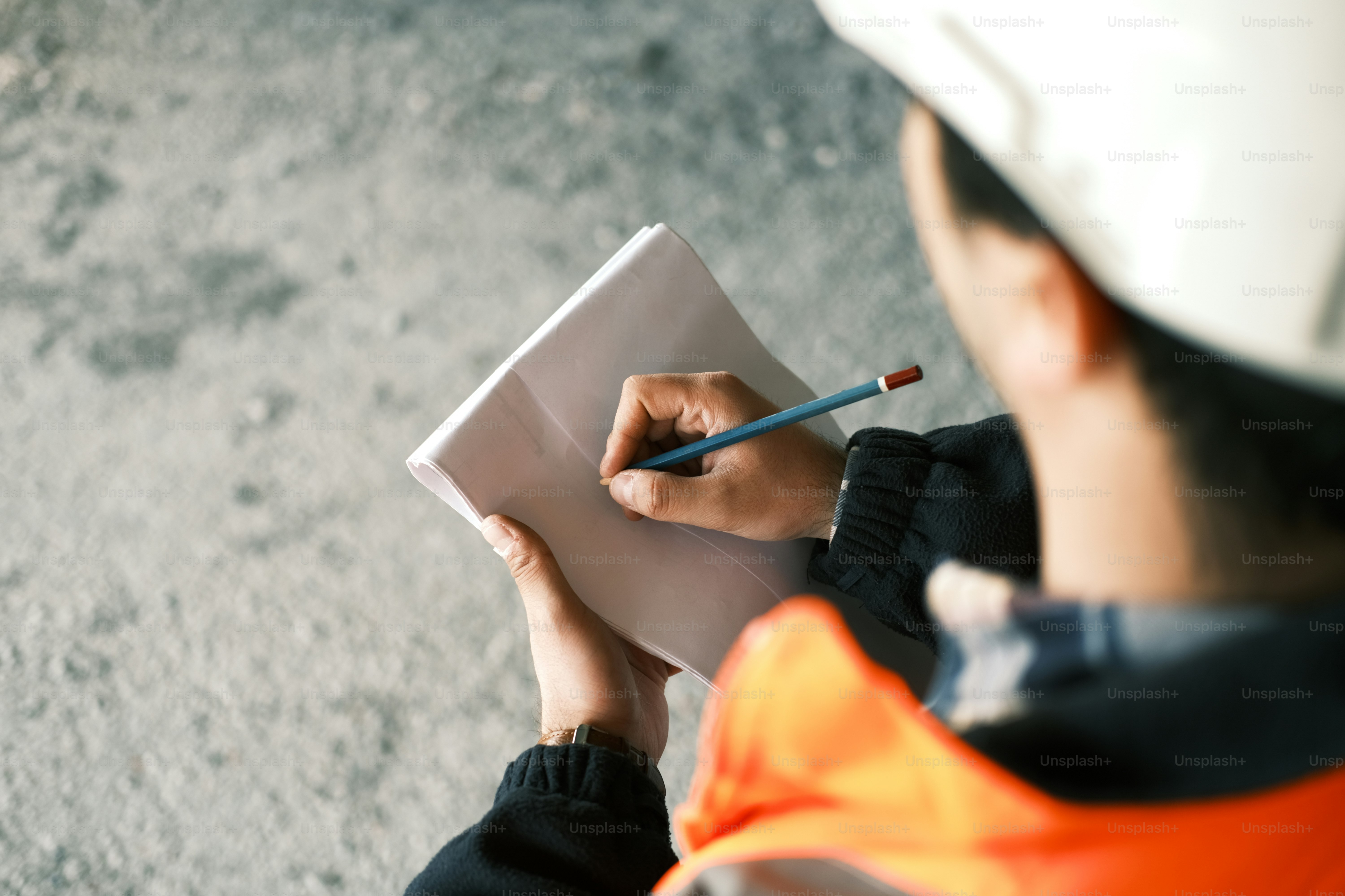 A construction worker writing on a concrete wall photo – Project ...