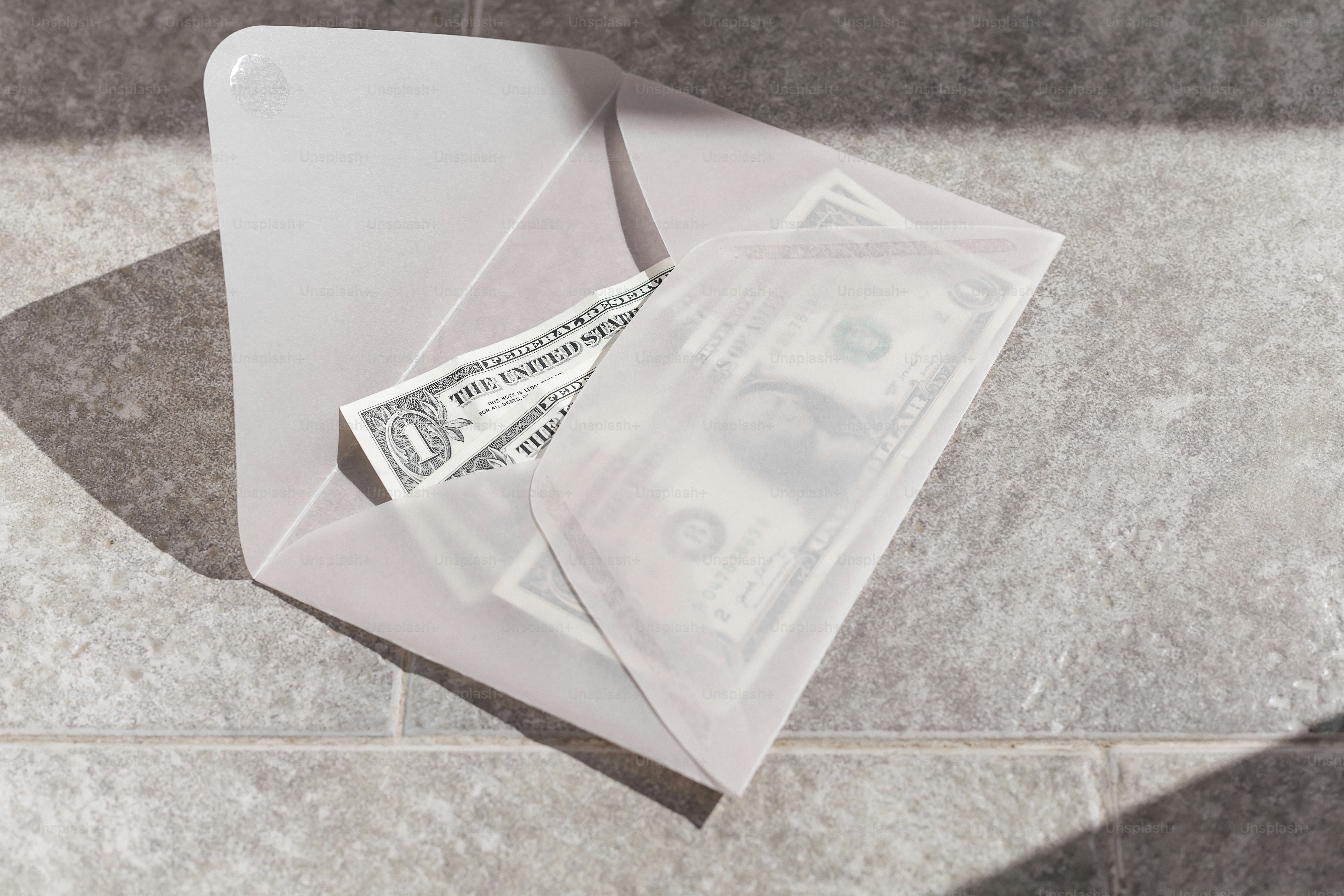 A white envelope with money sticking out of it photo – Currency Image ...