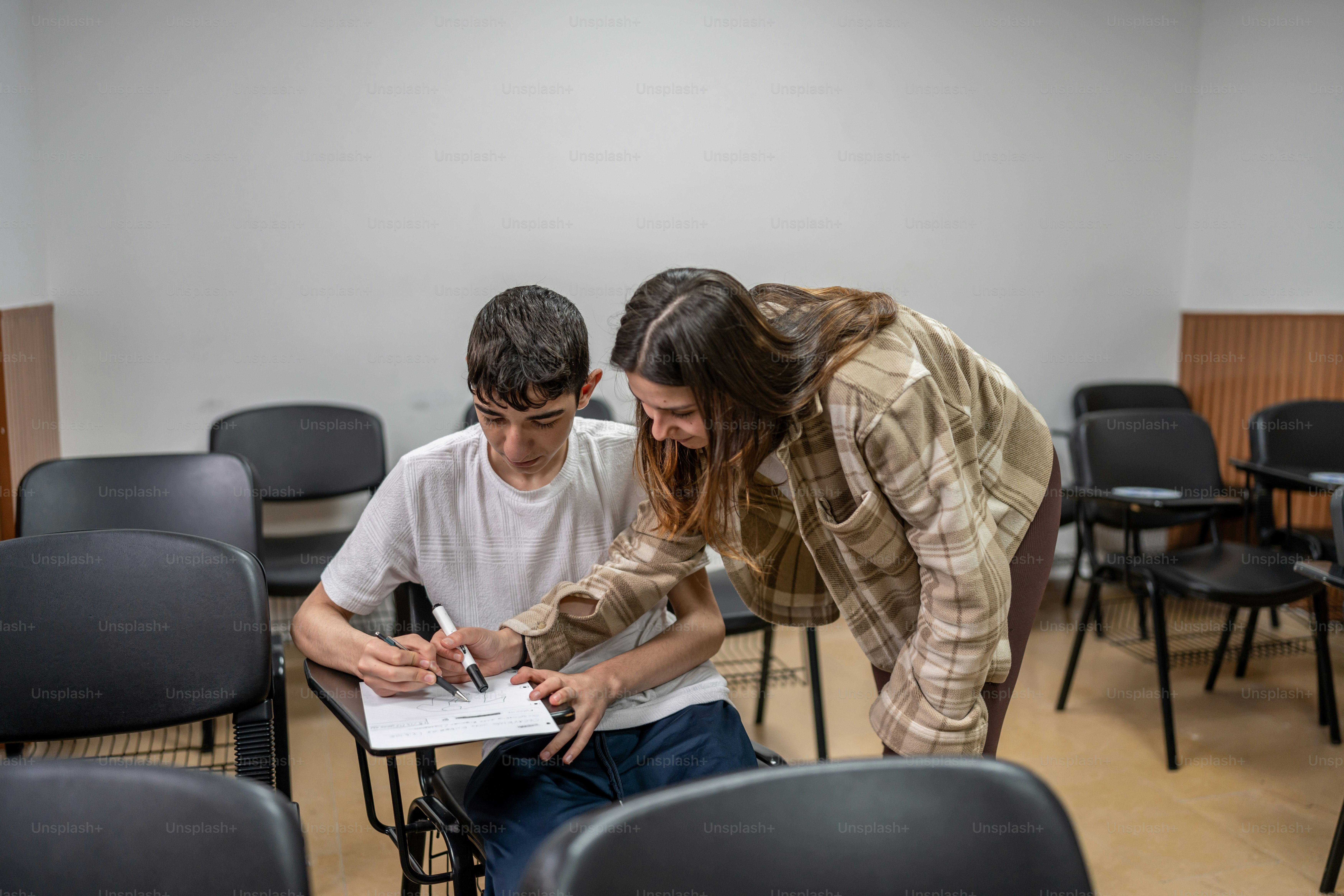 Two young men sitting at desks in a classroom photo – School Image on ...