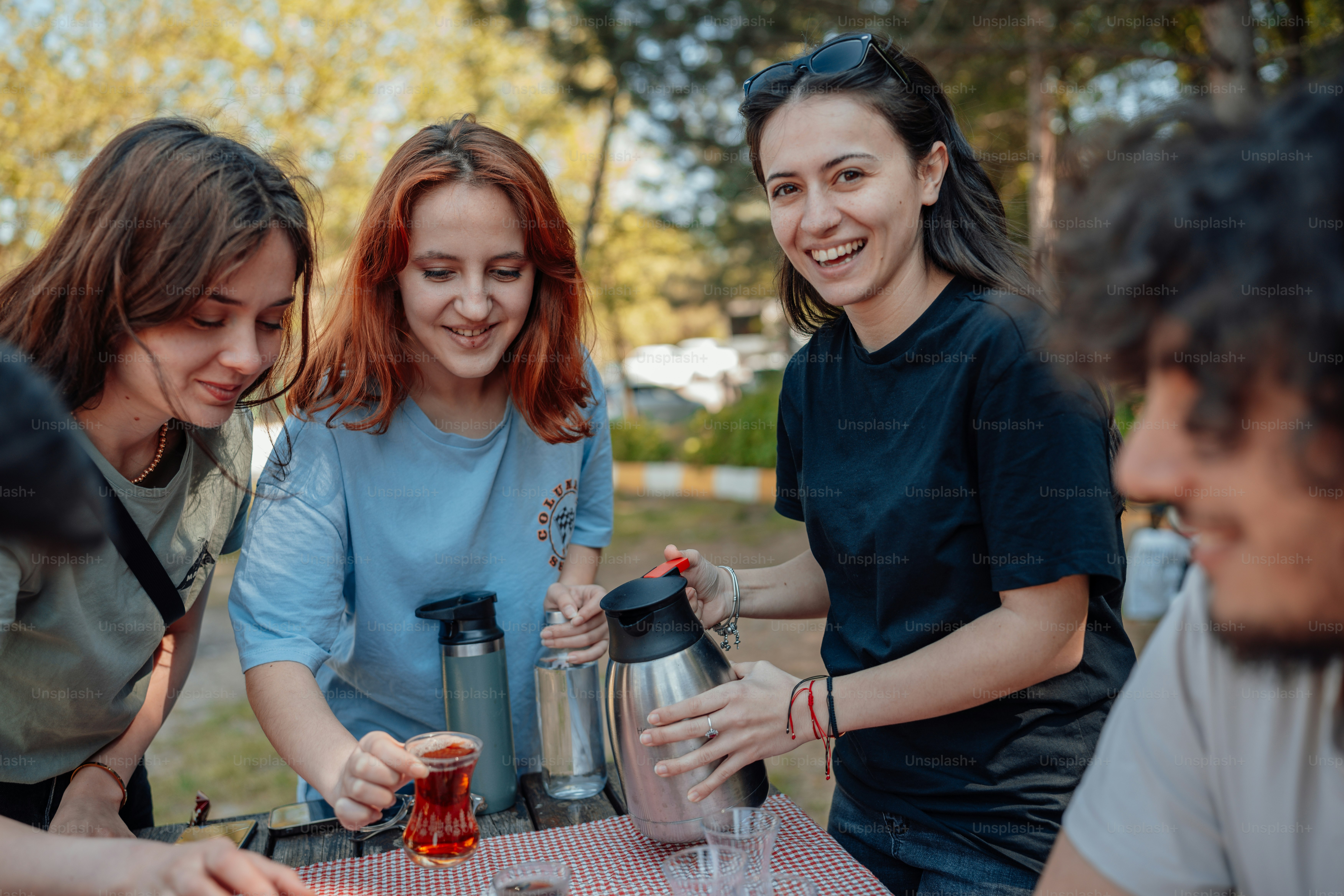 A group of people standing around a table with food photo – Party Image ...