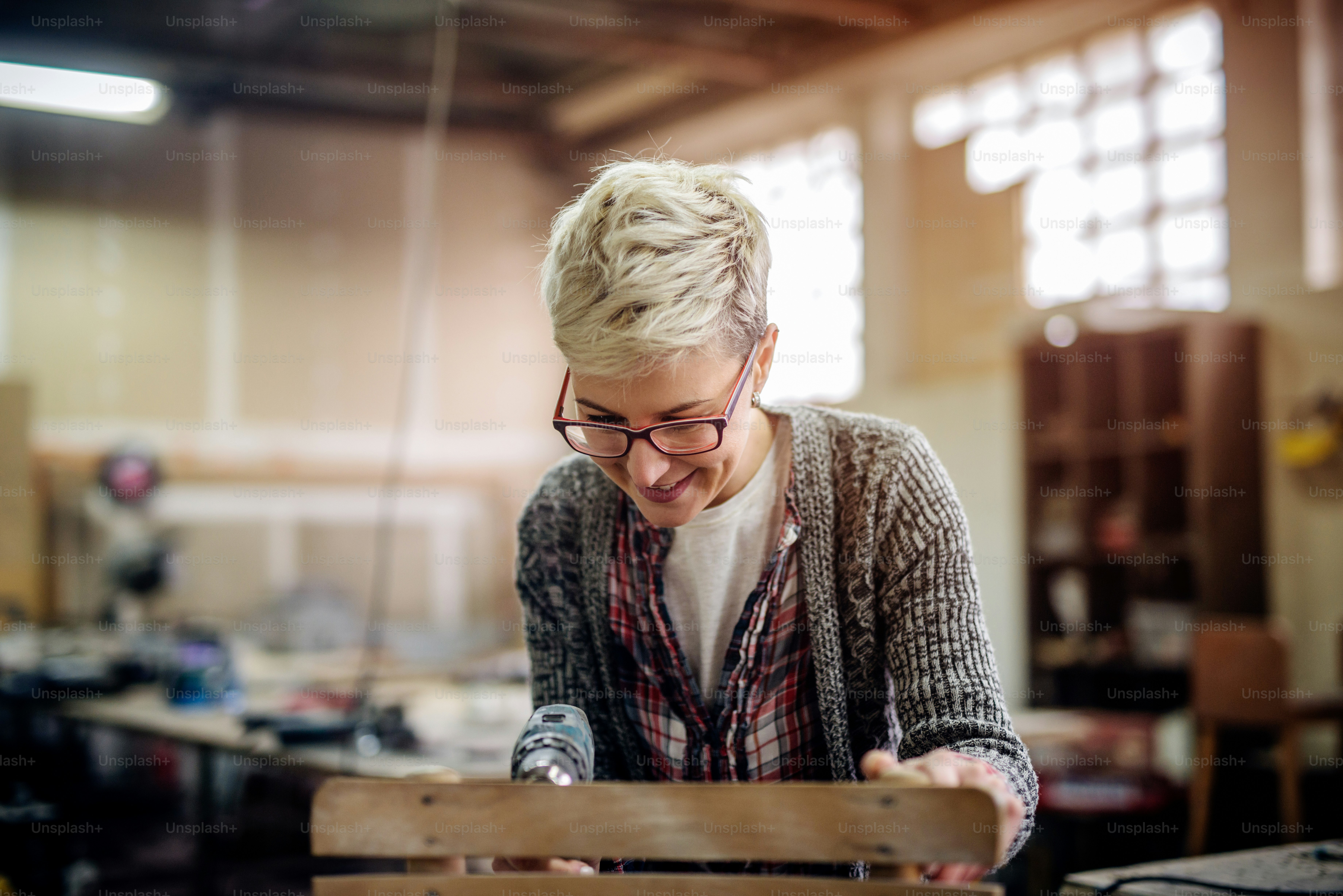Close up of woman making a chair. Carpenter workshop interior. photo ...