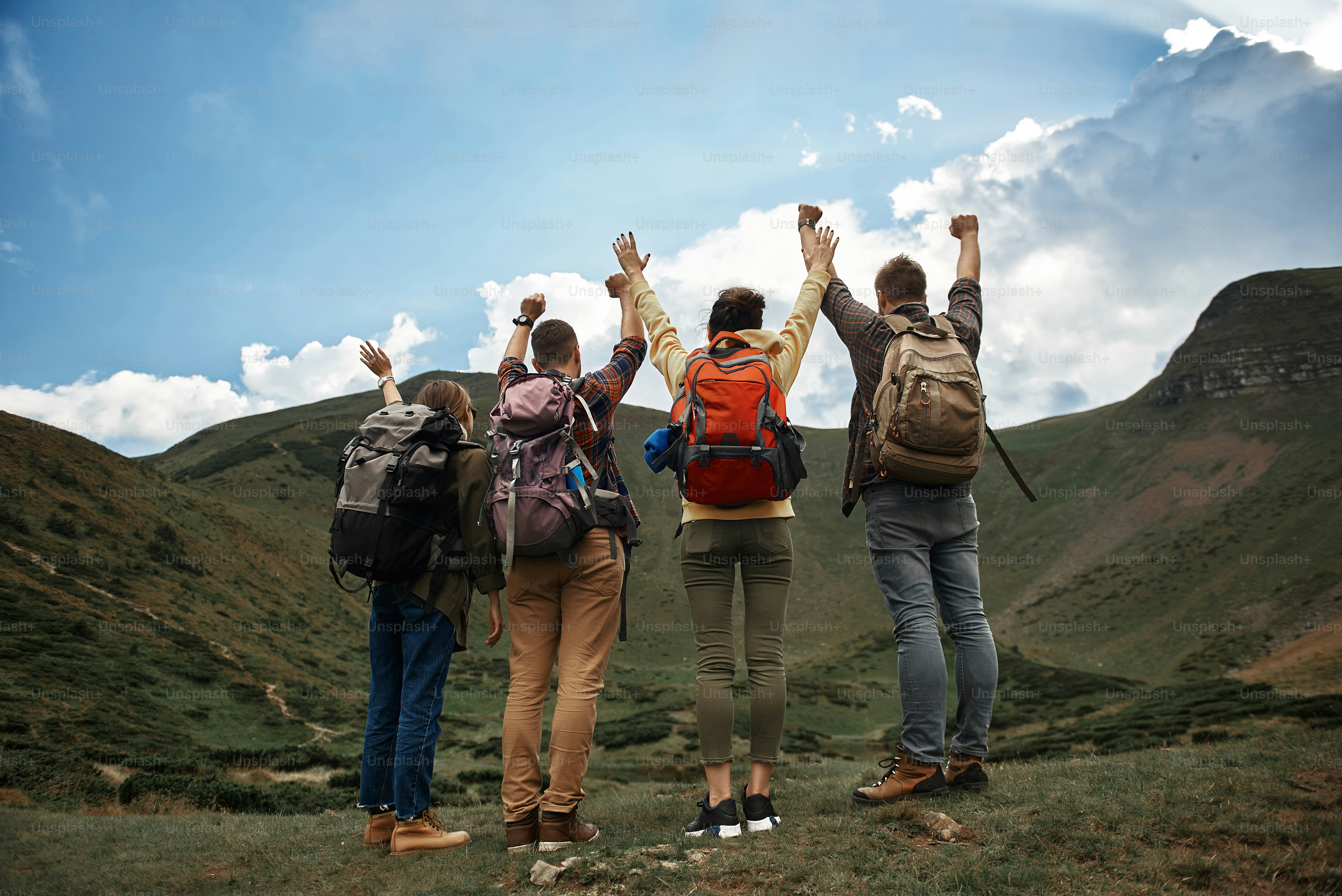 Winners. Excited young active people standing on the top of the hiss ...