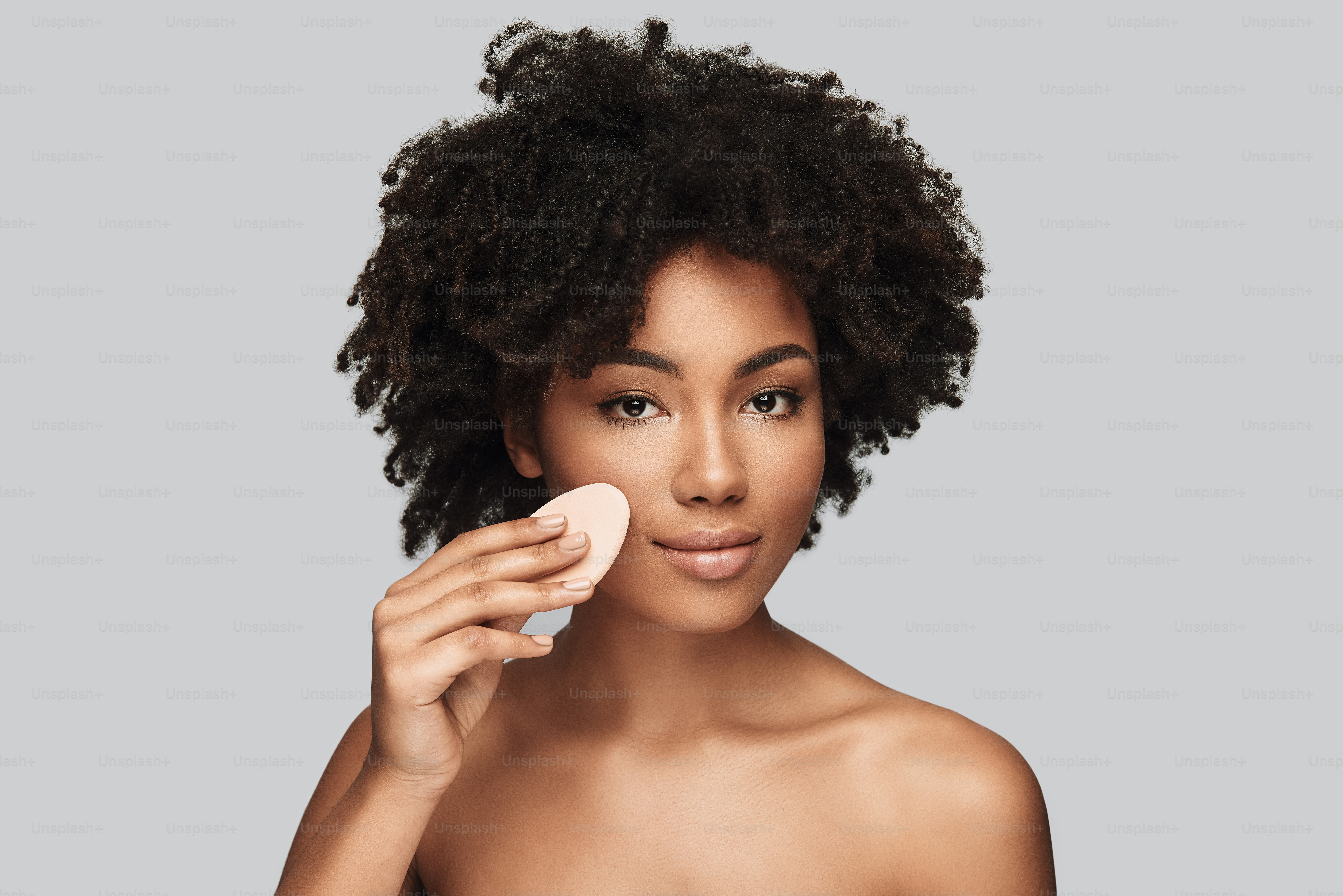 Attractive young African woman applying medical eye patch and smiling ...