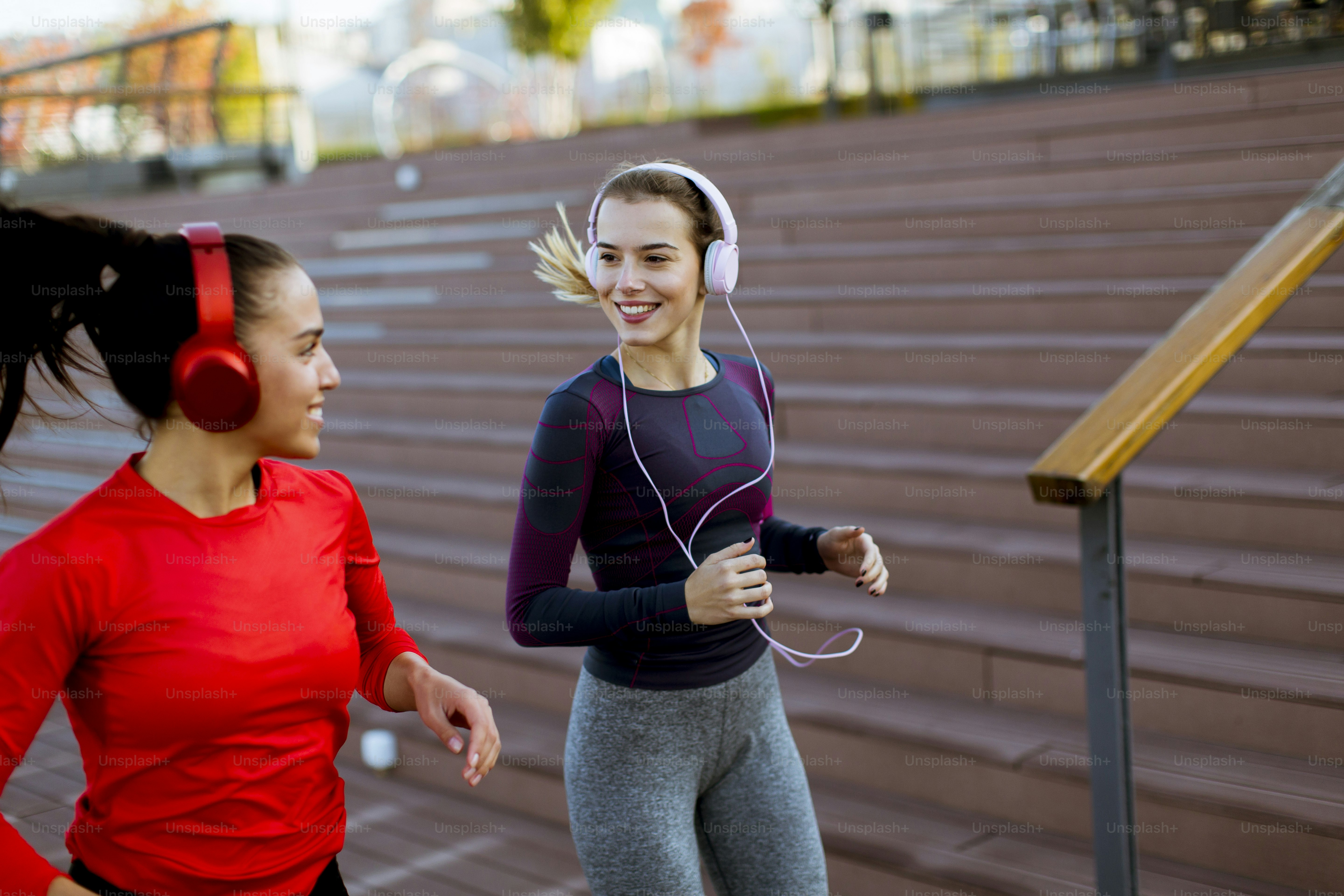 Two pretty young women running in urban area photo – Residential ...