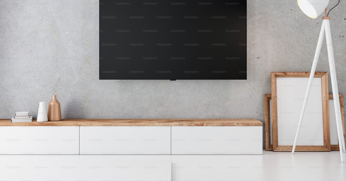 モダンなインテリアのコンクリート壁にぶら下がっている空白の画面を持つスマートテレビモックアップ。3dレンダリングの写真 テレビ台
