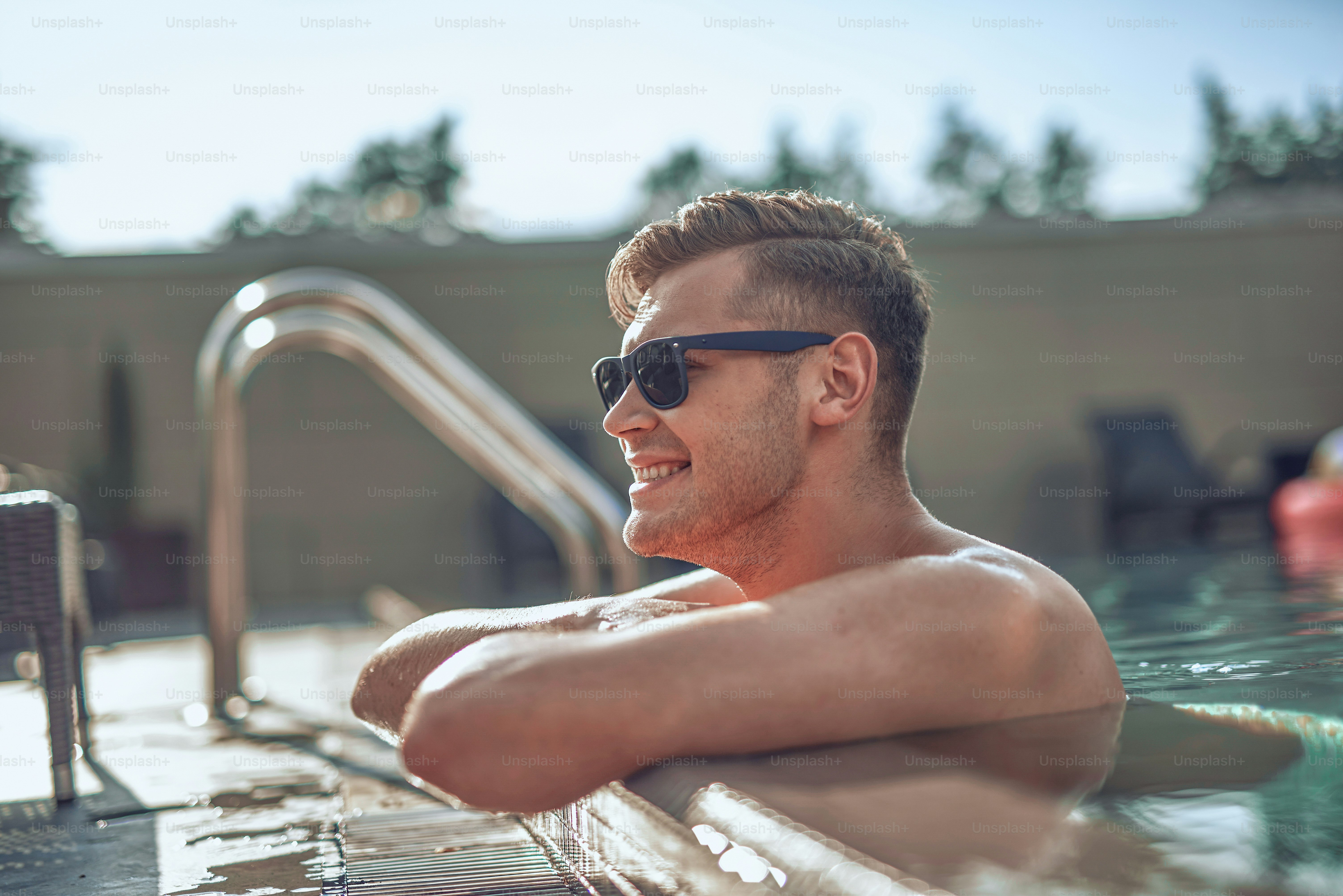 Attractive Caucasian handsome man having a rest in the swimming pool ...