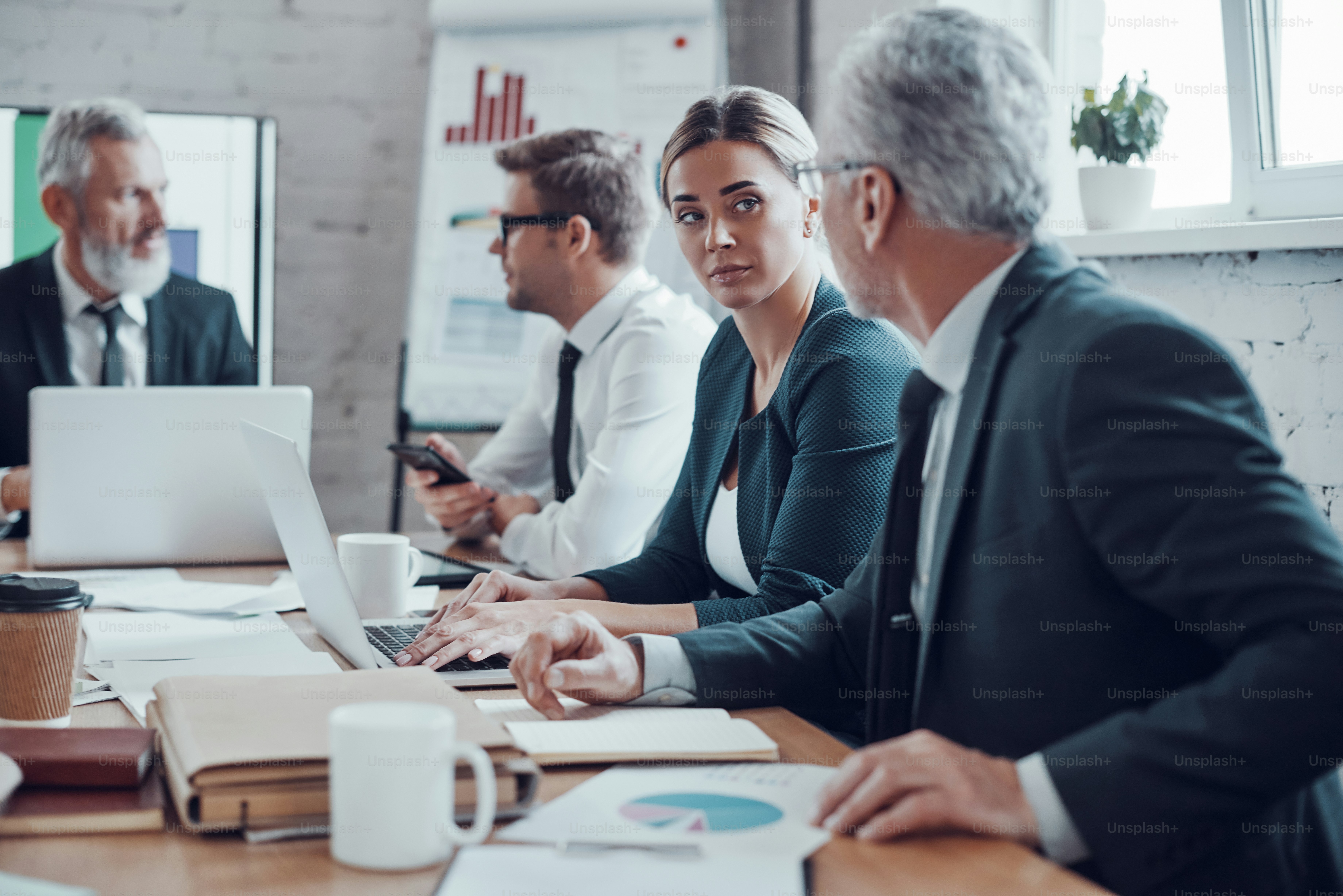 Cheerful business team giving each other high five to success while ...