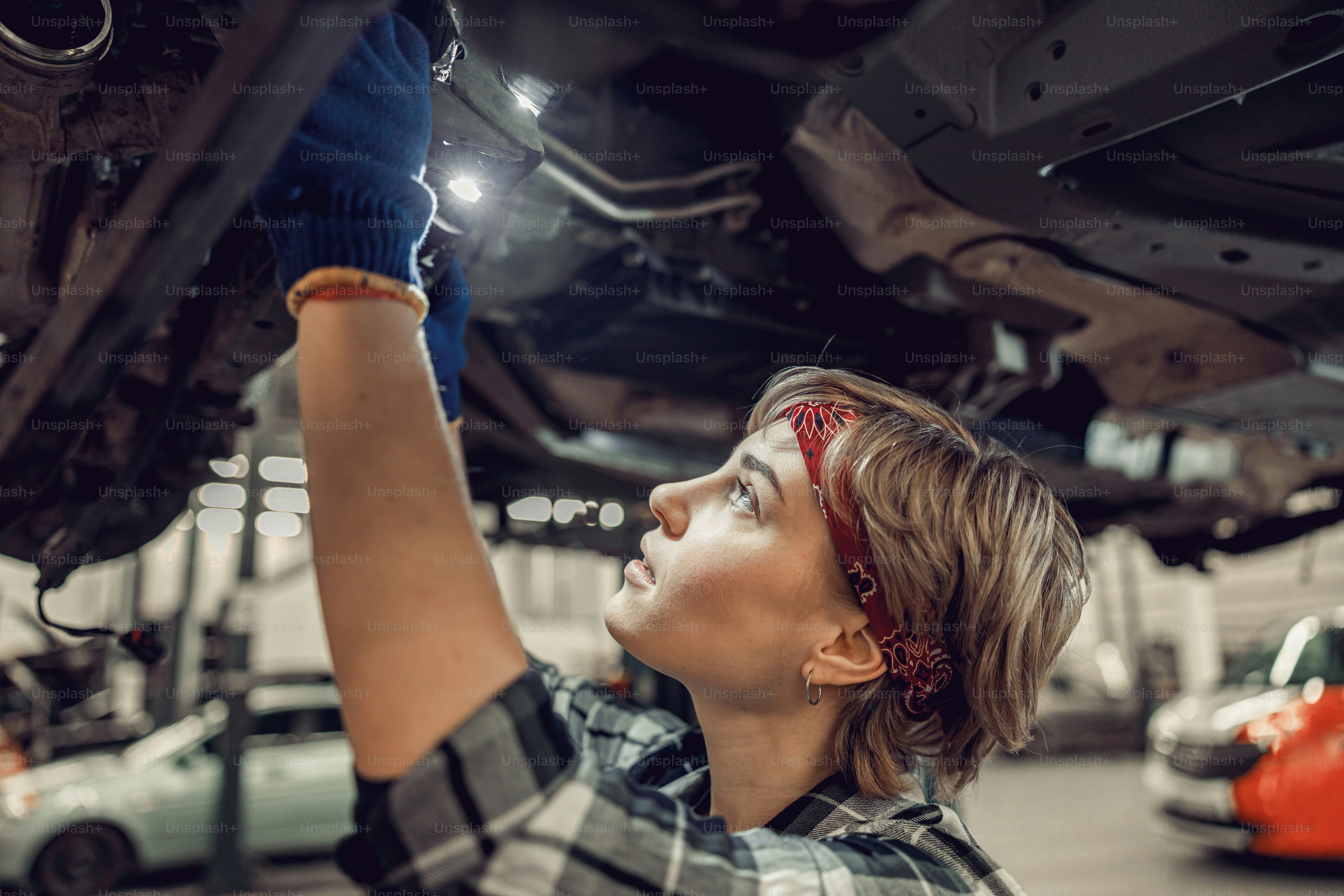 Professional mechanic inspecting the car bottom in a garage photo – Car ...