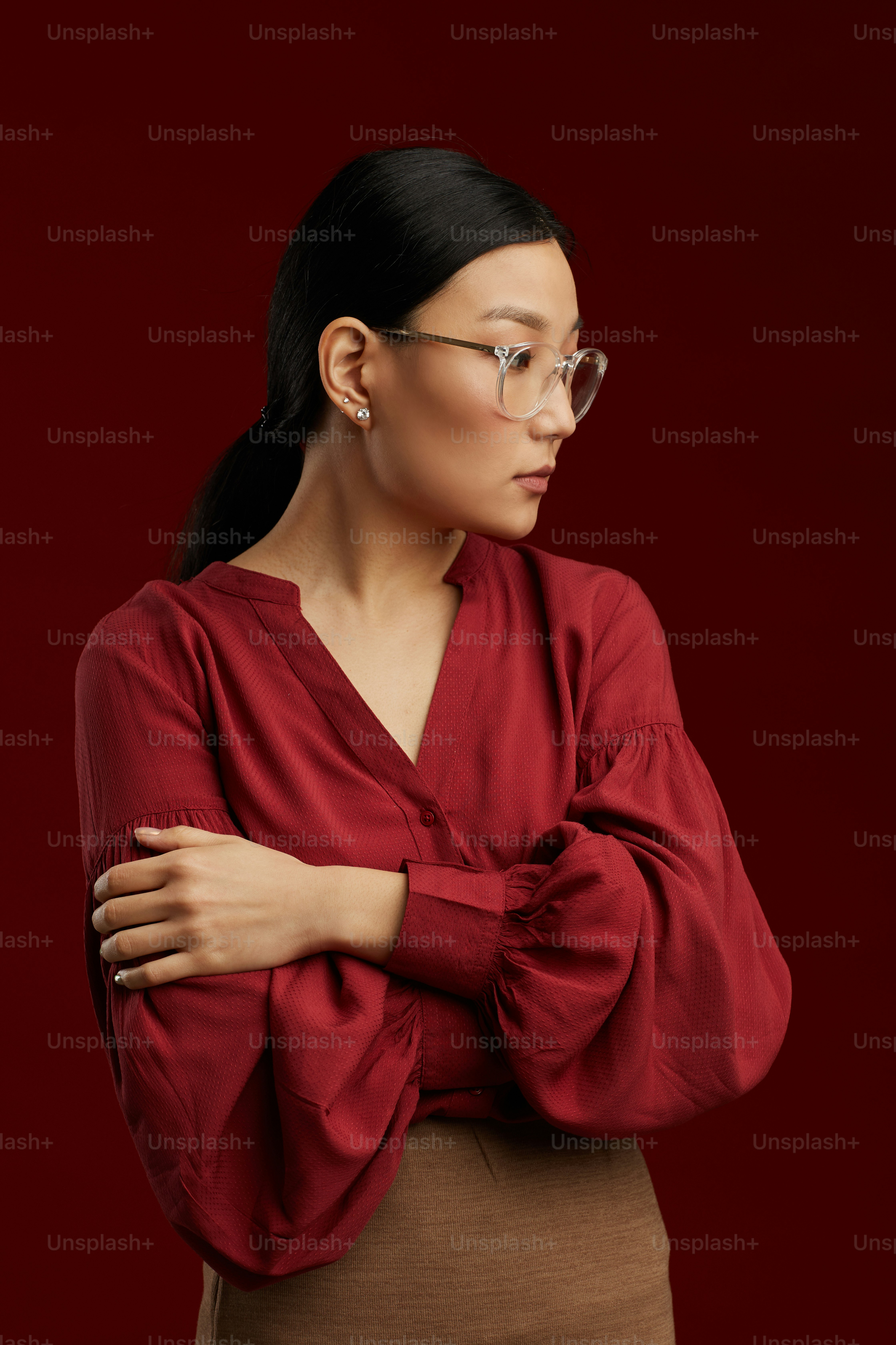 Waist up portrait of Asian woman wearing red blouse posing stiffly ...