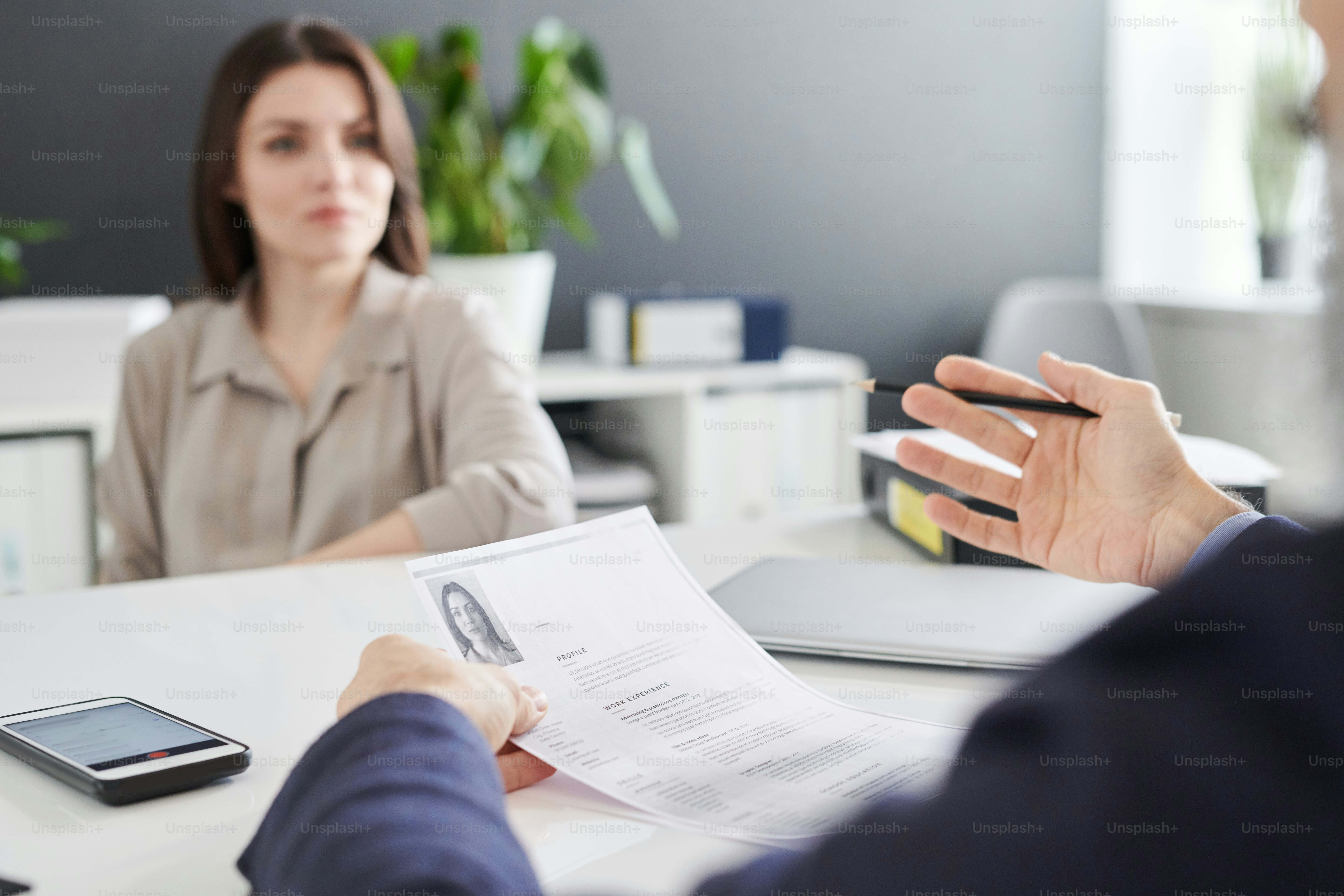 Hands of contemporary psychologist or employer with pen and resume of ...