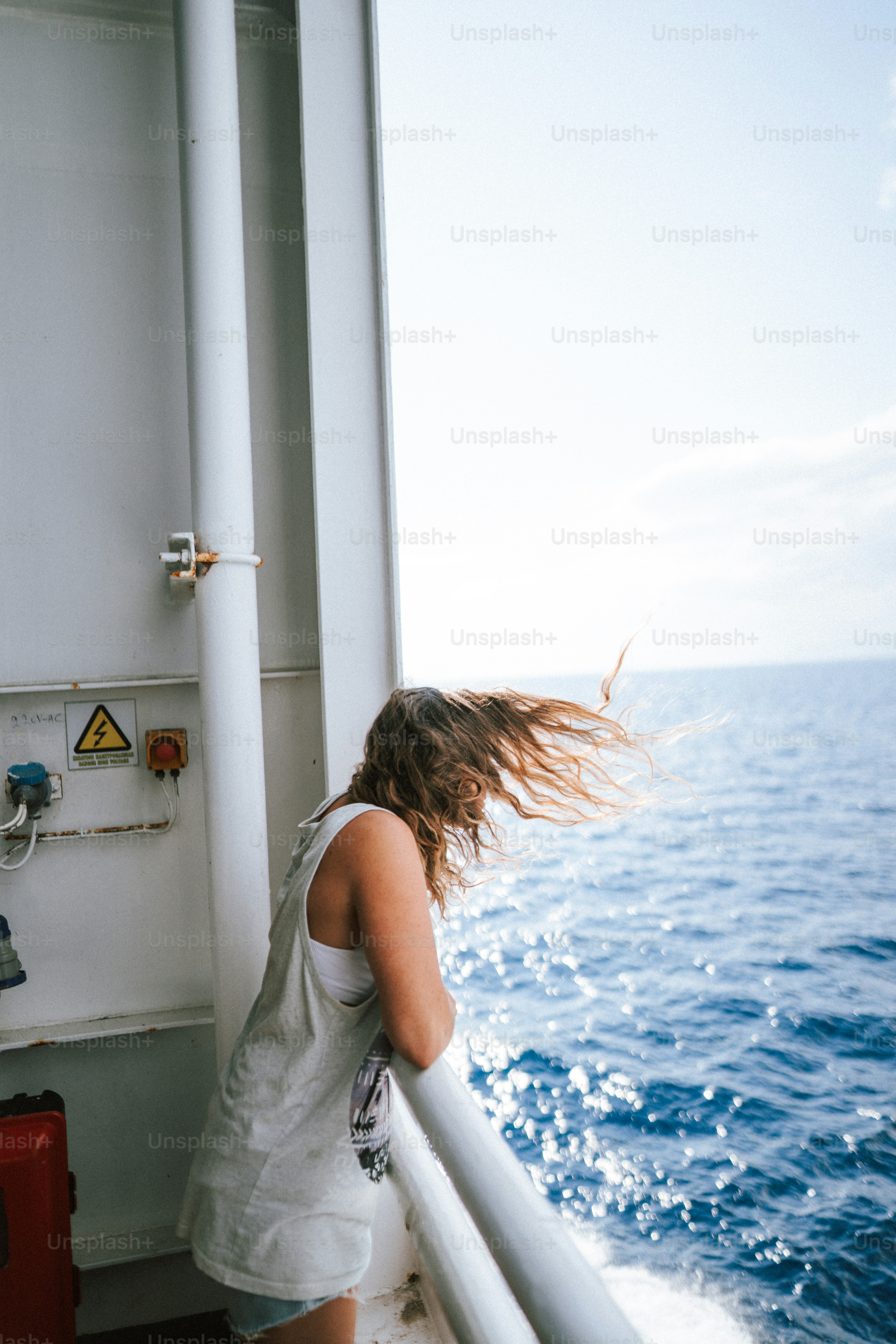A woman standing on a boat looking out at the ocean photo – Tour Image ...