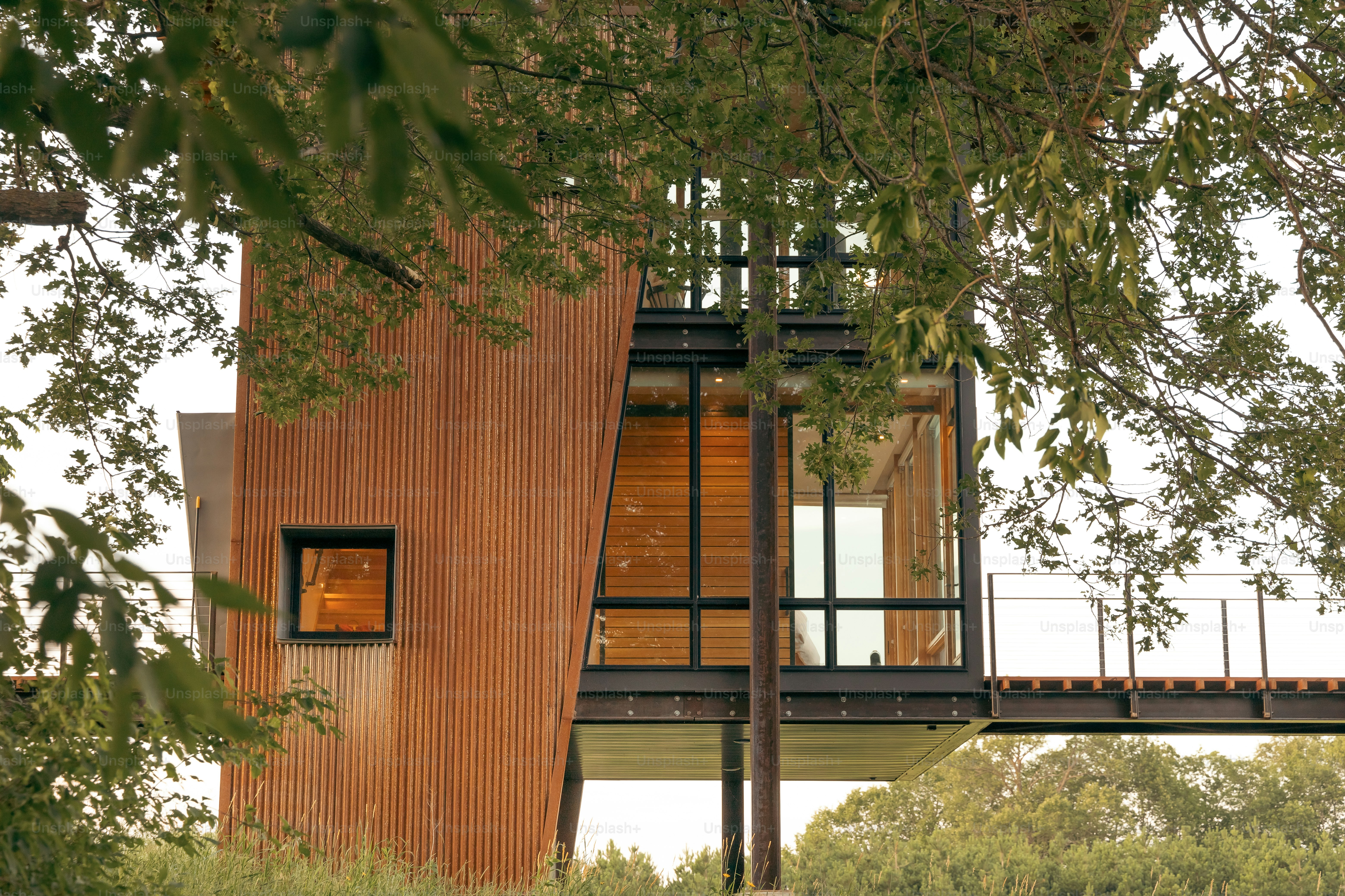A tall wooden building with a glass window on top of it photo – Modern ...