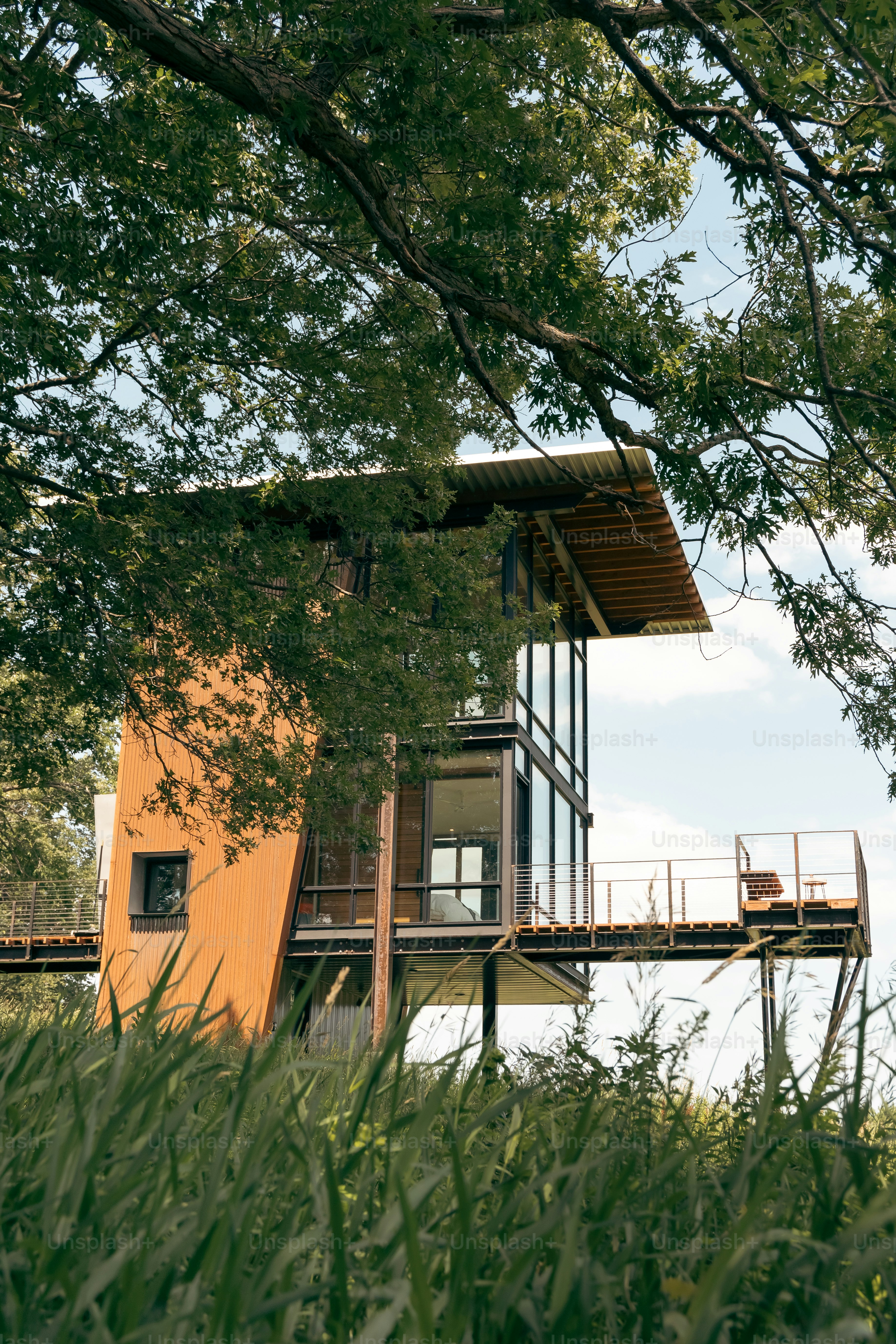 A tall wooden building with a glass window on top of it photo – House ...