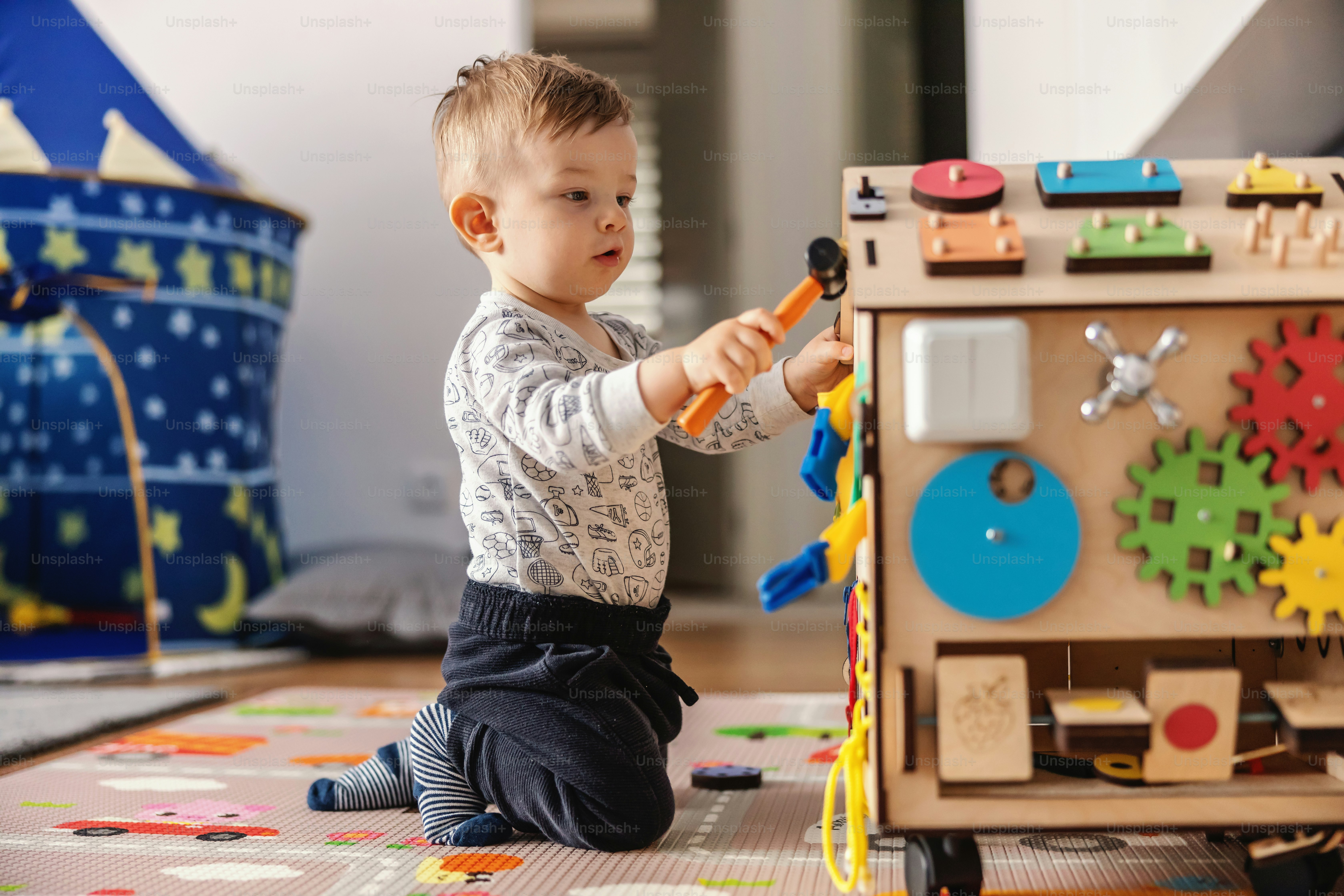 Adorable toddler playing interactive games for good development at home ...
