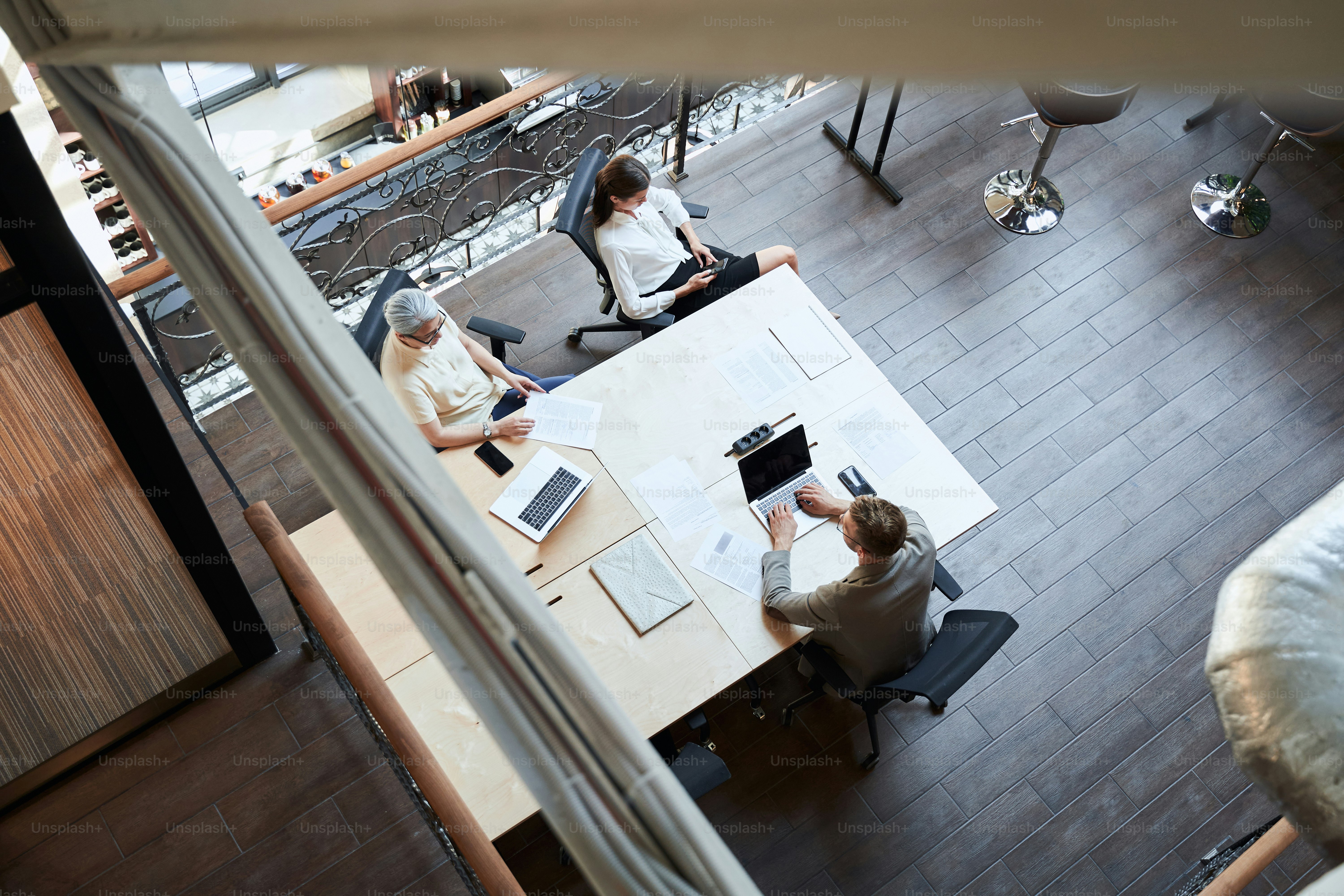 Top- view of three professional-looking people of different age working ...