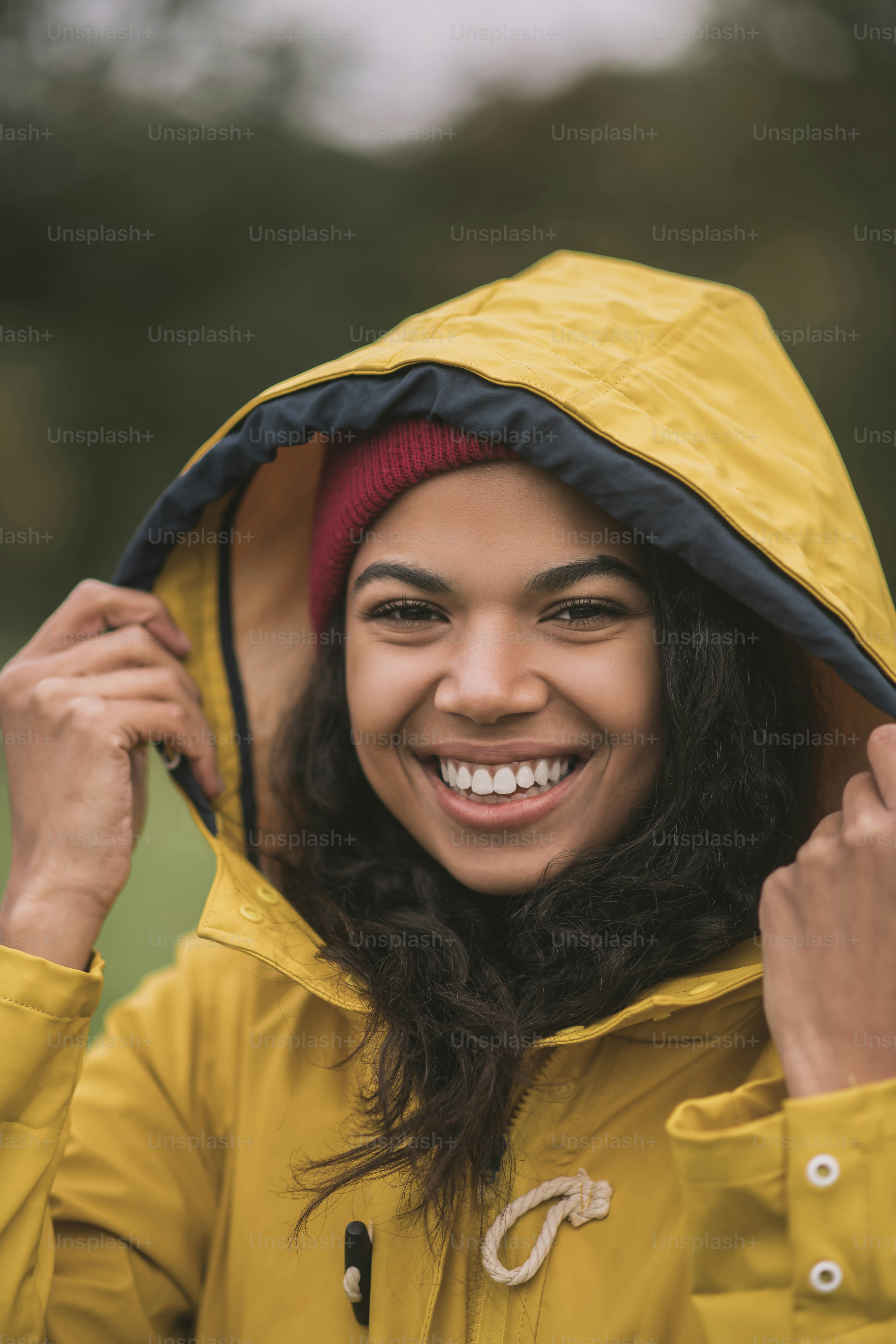 Fille souriante. Jolie mulatta en manteau jaune souriant joliment photo ...