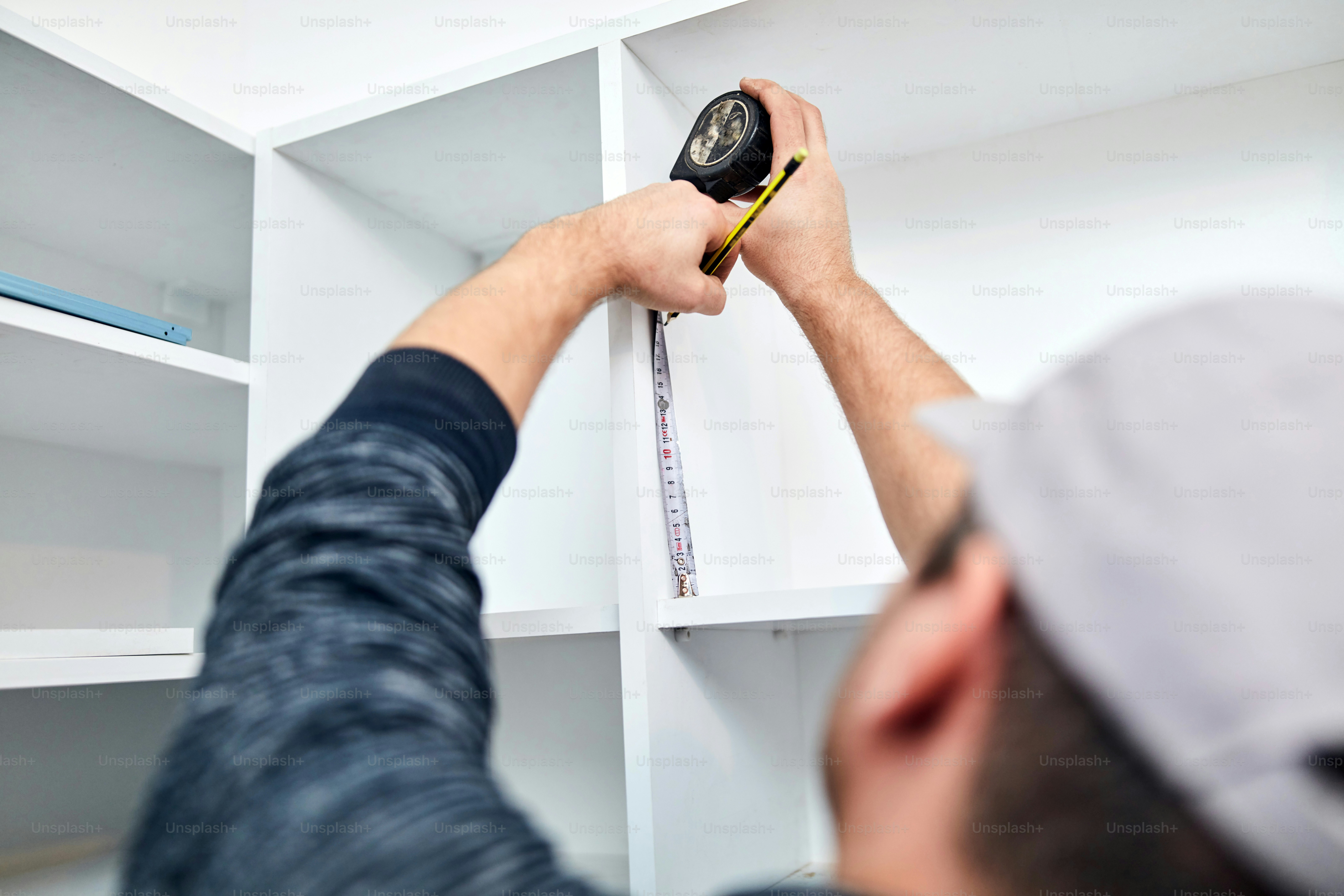 Handyman worker assembling furniture and fixing it. photo – Tape ...