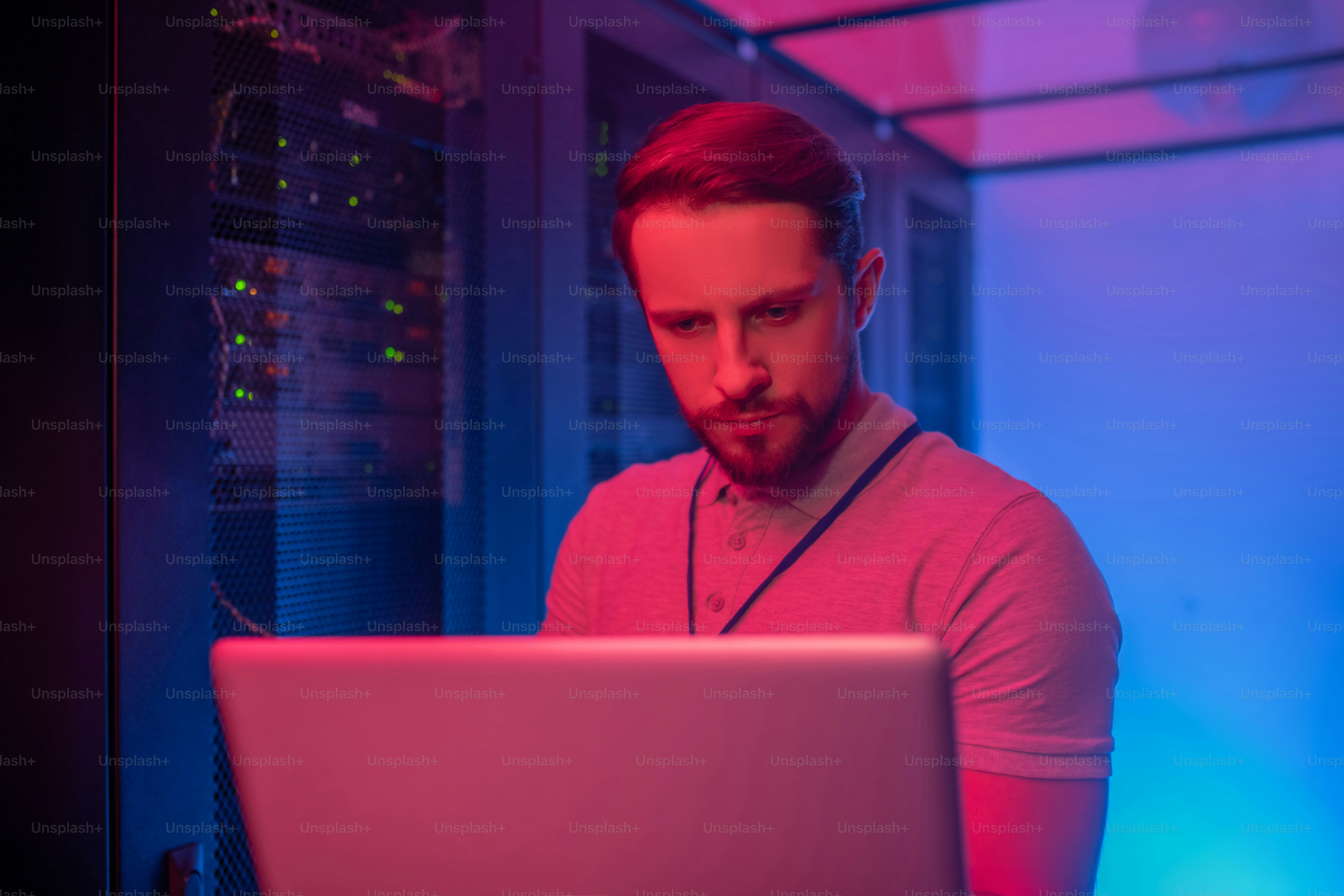 Administration. Focused smart young man with laptop standing near the ...