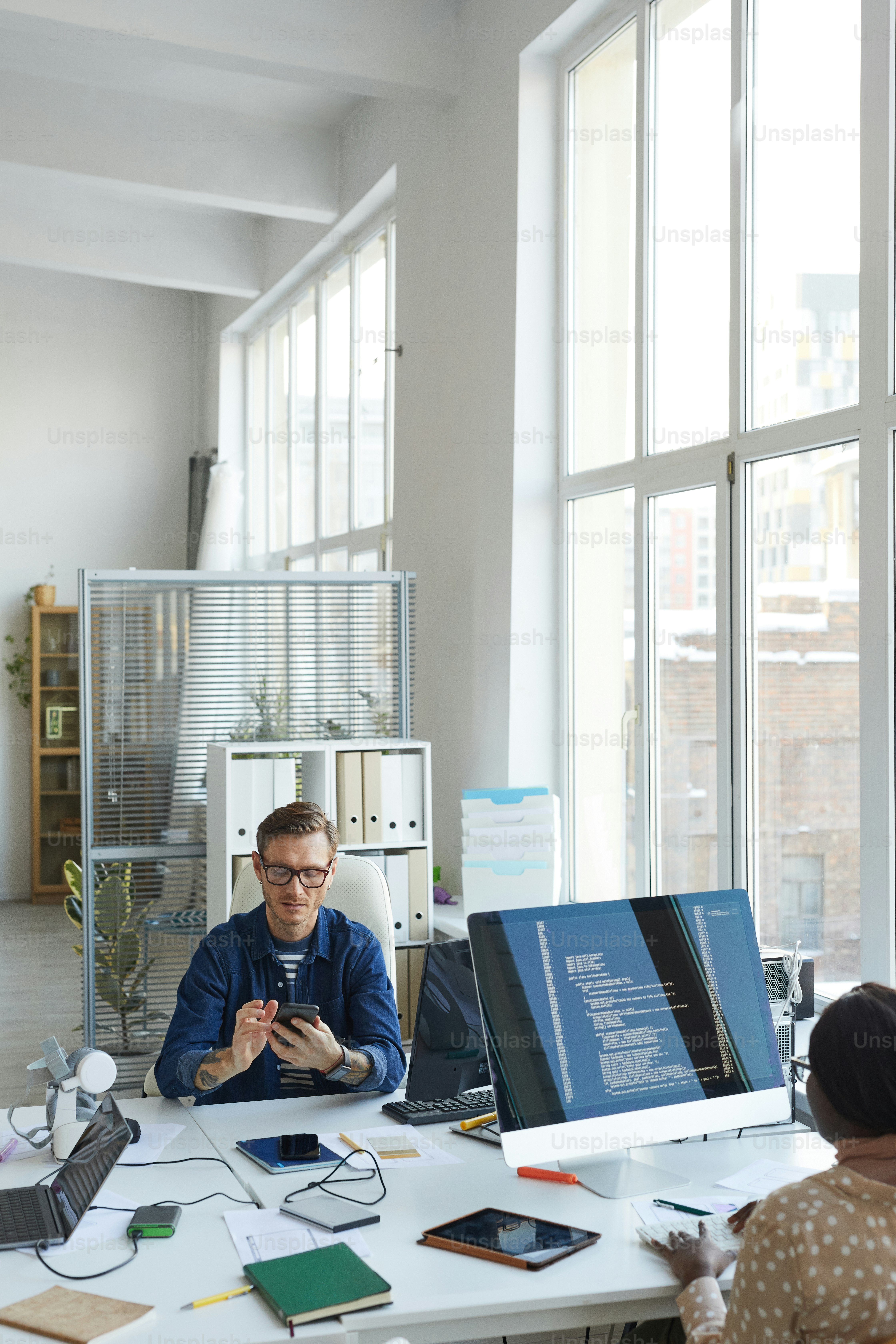 Diverse team of young software programmers using computers and writing code while collaborating ...