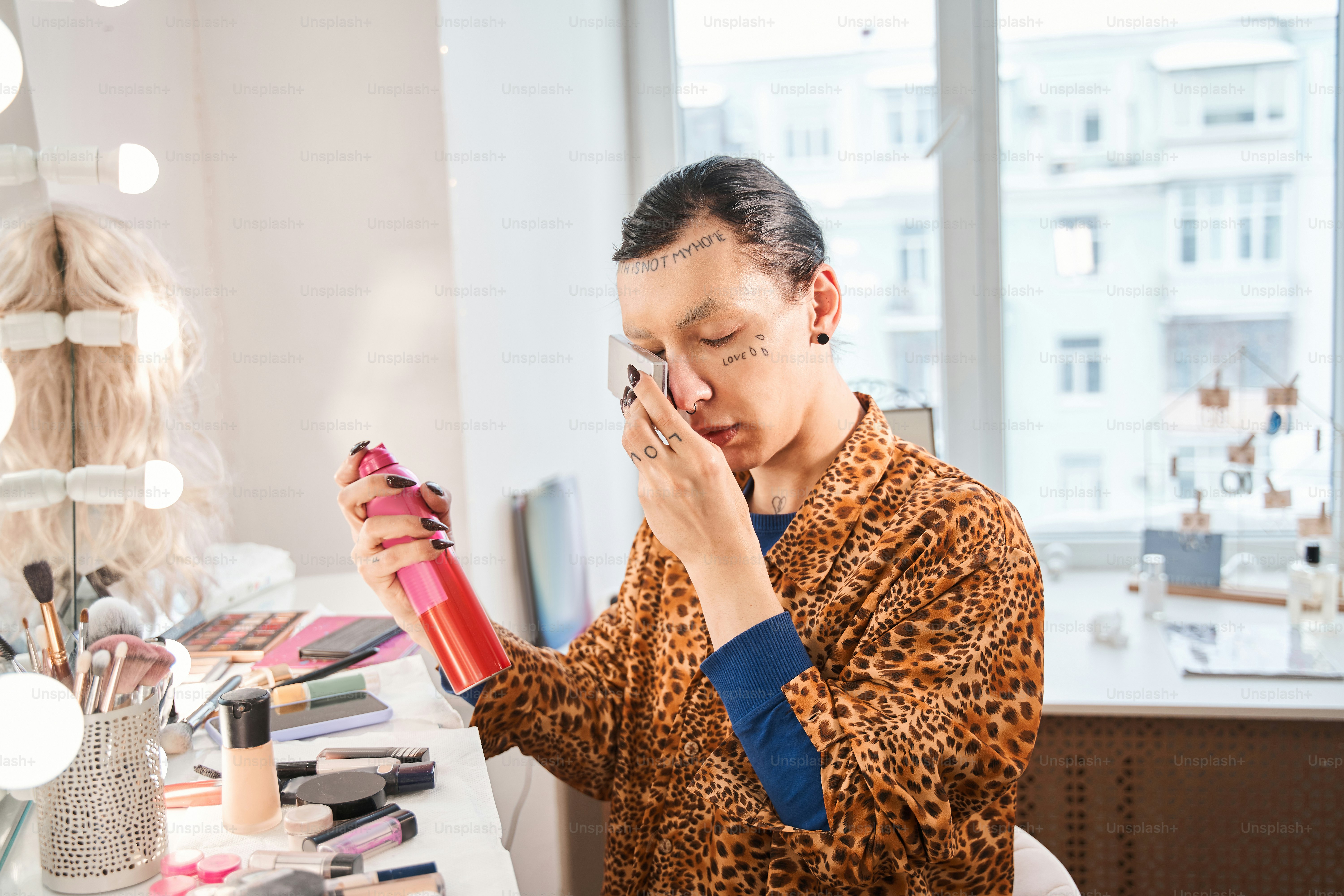 Préparation du maquillage. Vue portrait de la drag queen assise devant ...